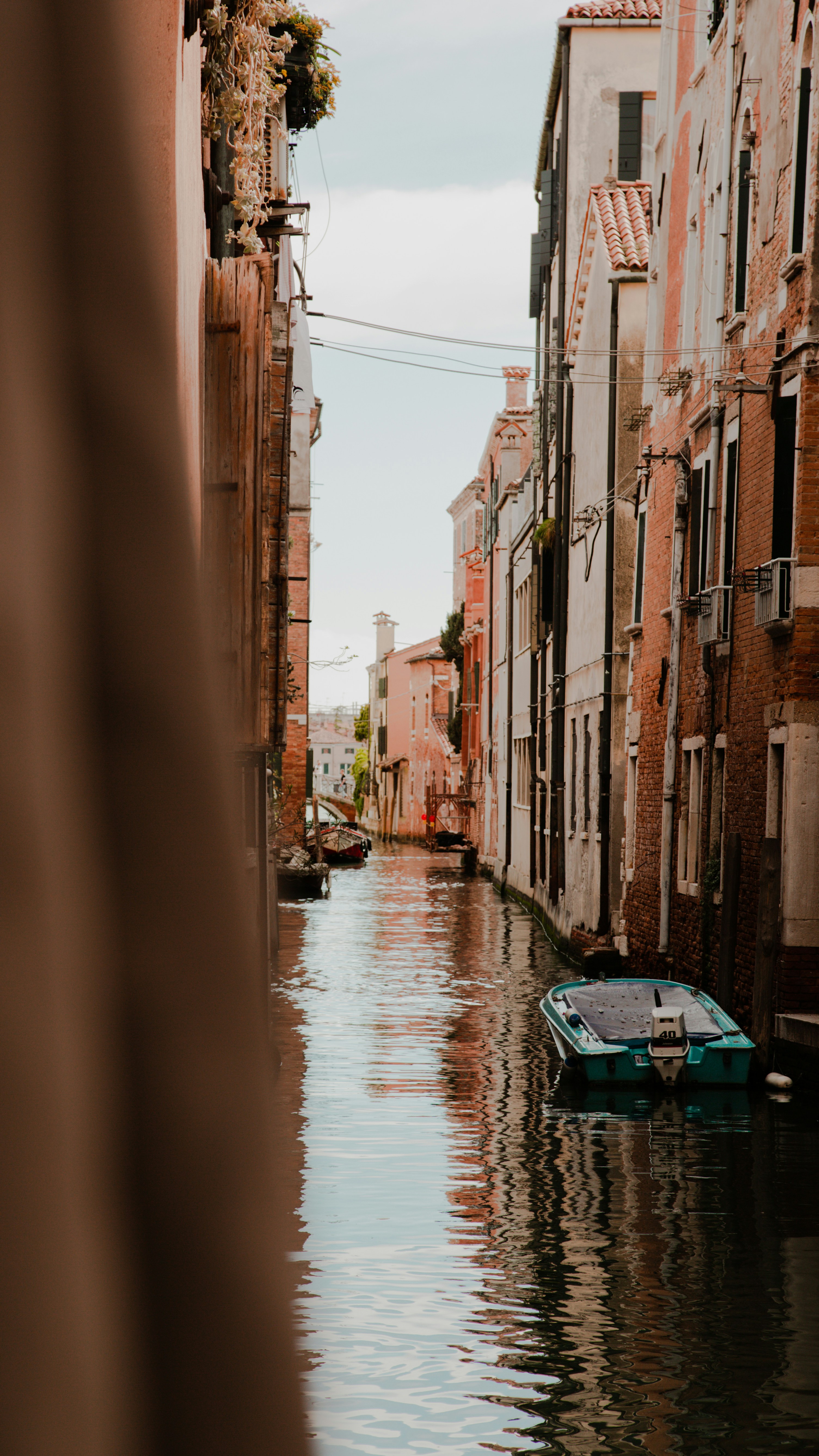 A boat floating down a river next to tall buildings photo – Free Road ...