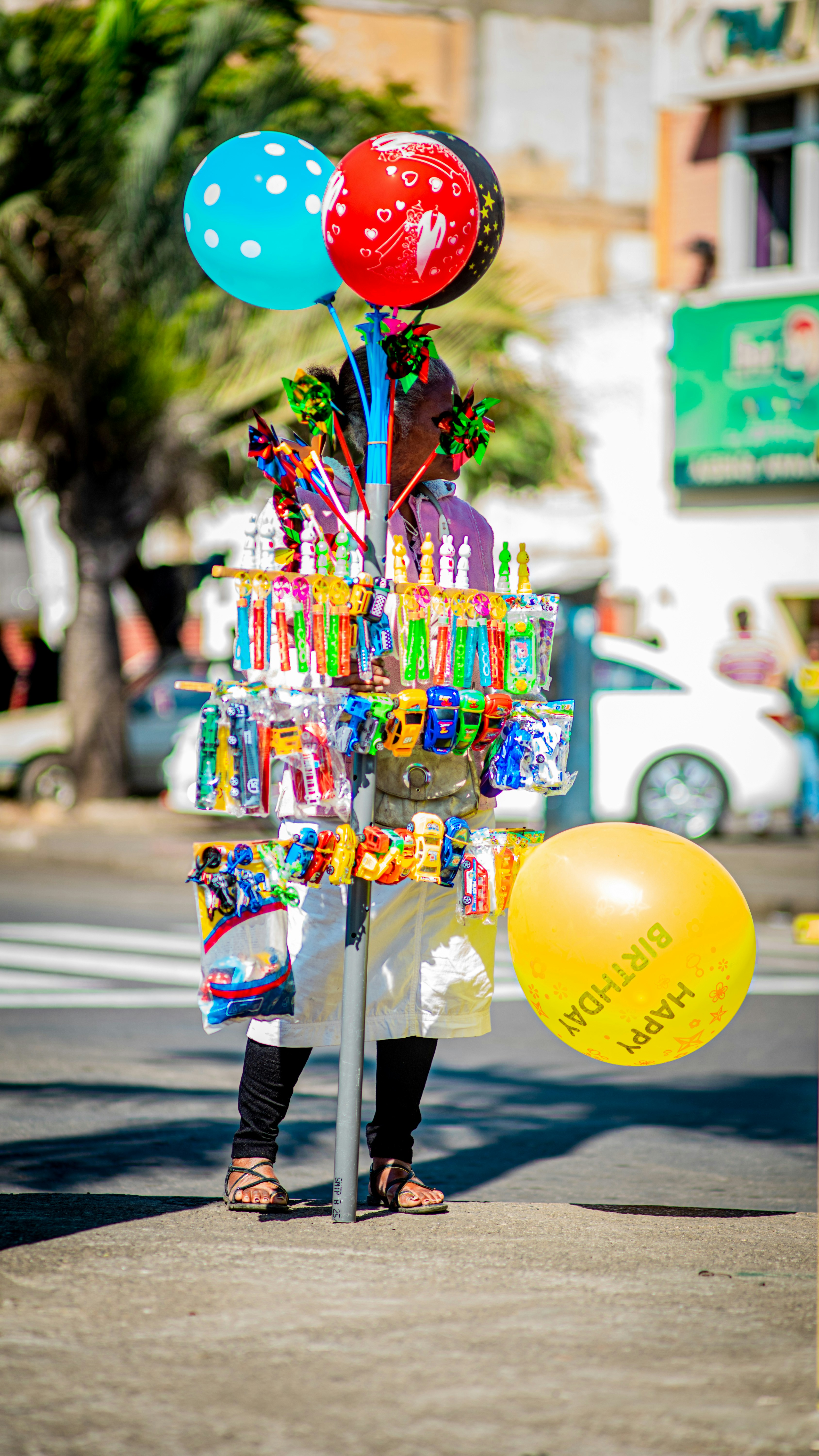 Balloon Bouquet Street Vendor: A Kaleidoscope of Toys on a Sunlit Sidewalk