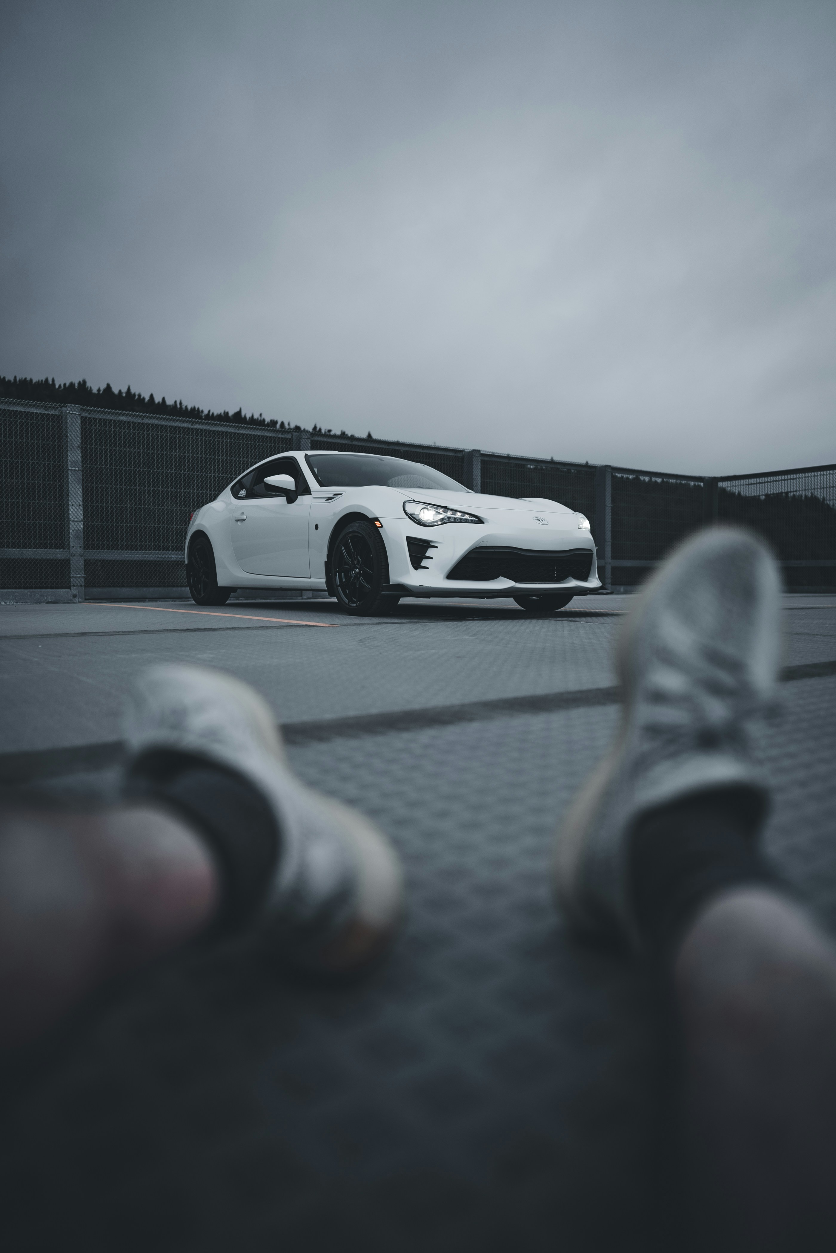 Rooftop Reverie: A White Sports Coupe Anchors the Frame Above Blurred Ground