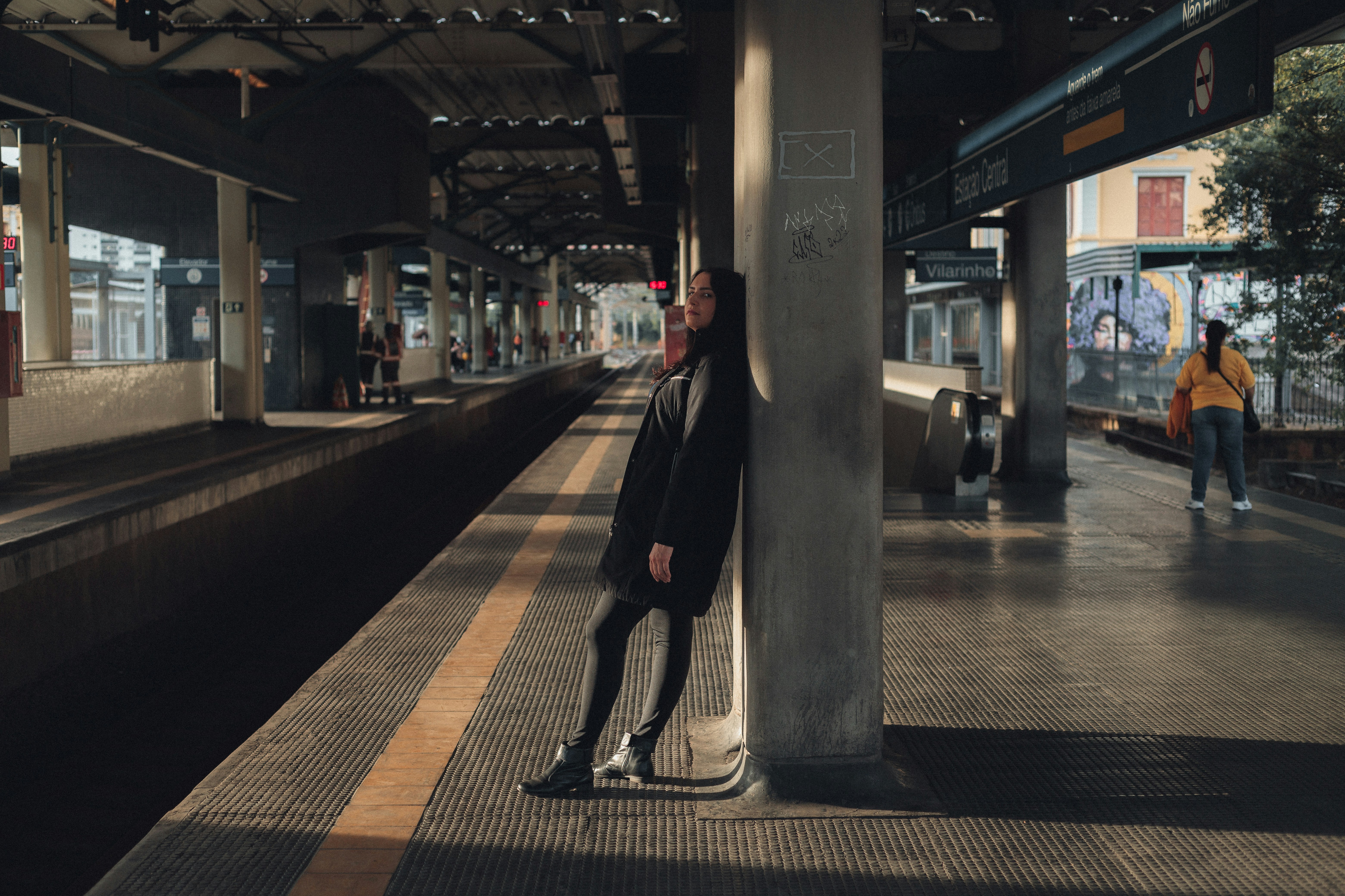 A man leaning against a pole in a train station photo – Free Subway ...