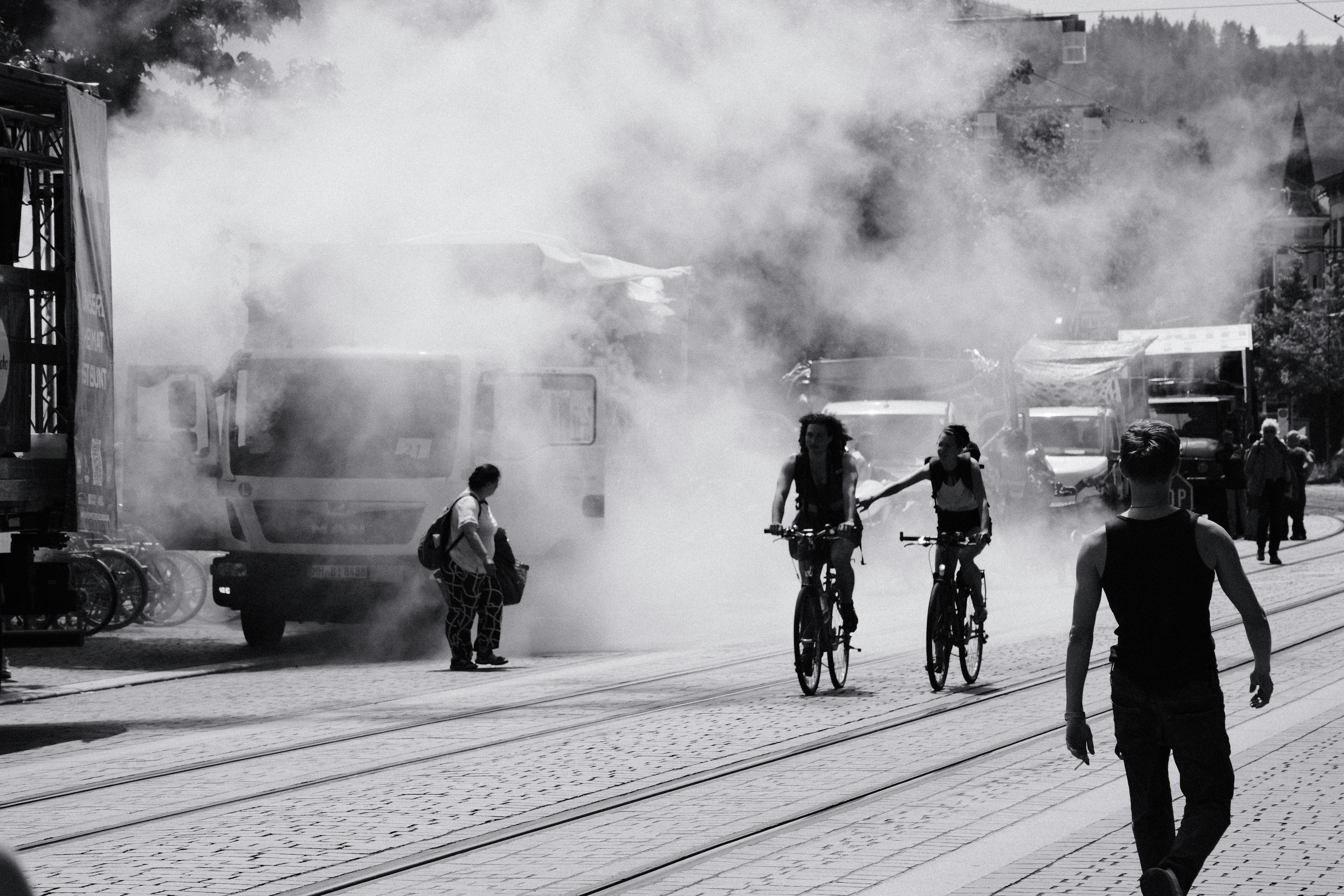 Cyclists Cut Through a Steam-Cloaked Urban Crossing