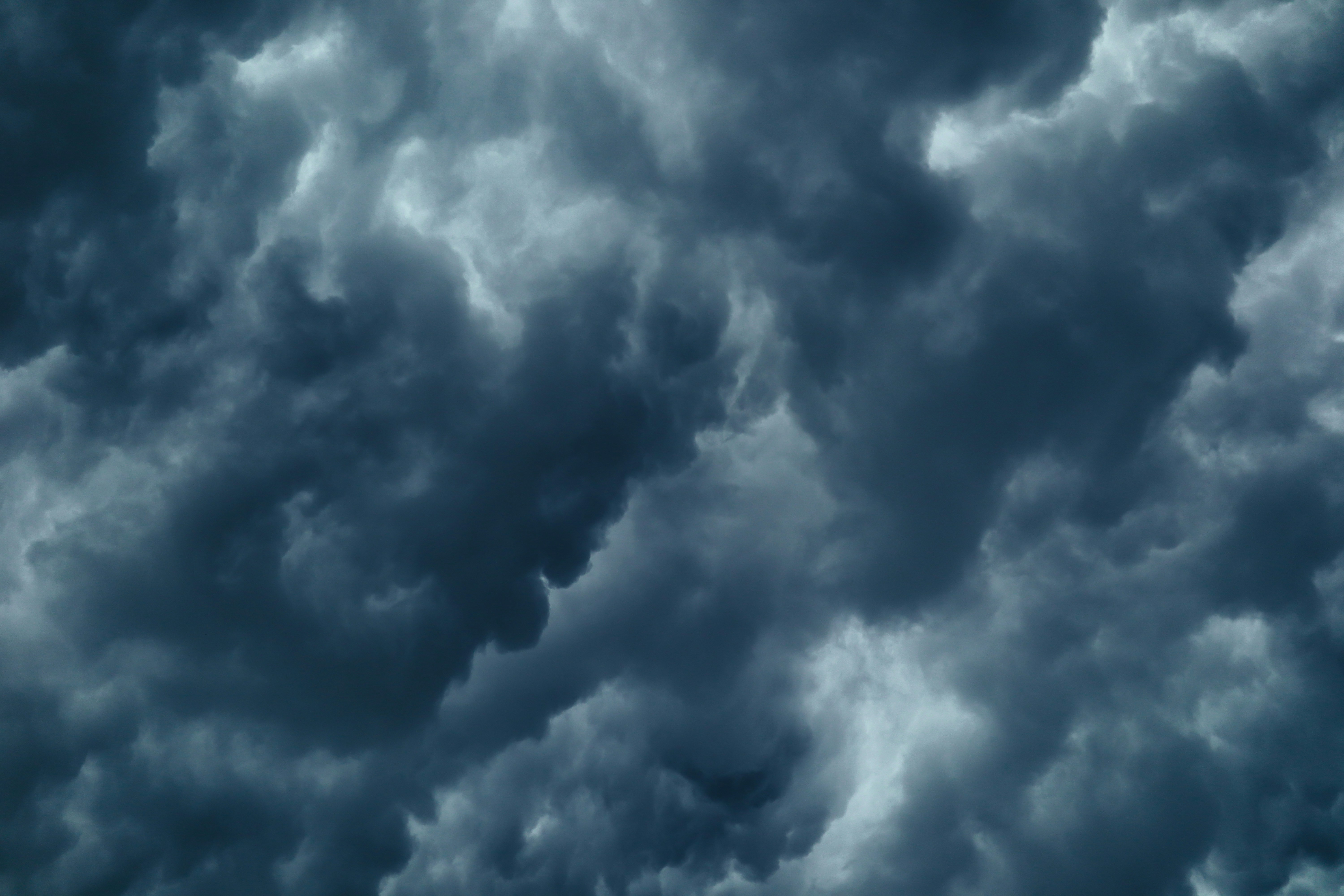A very cloudy sky with a plane in the foreground photo – Free Cloudy ...