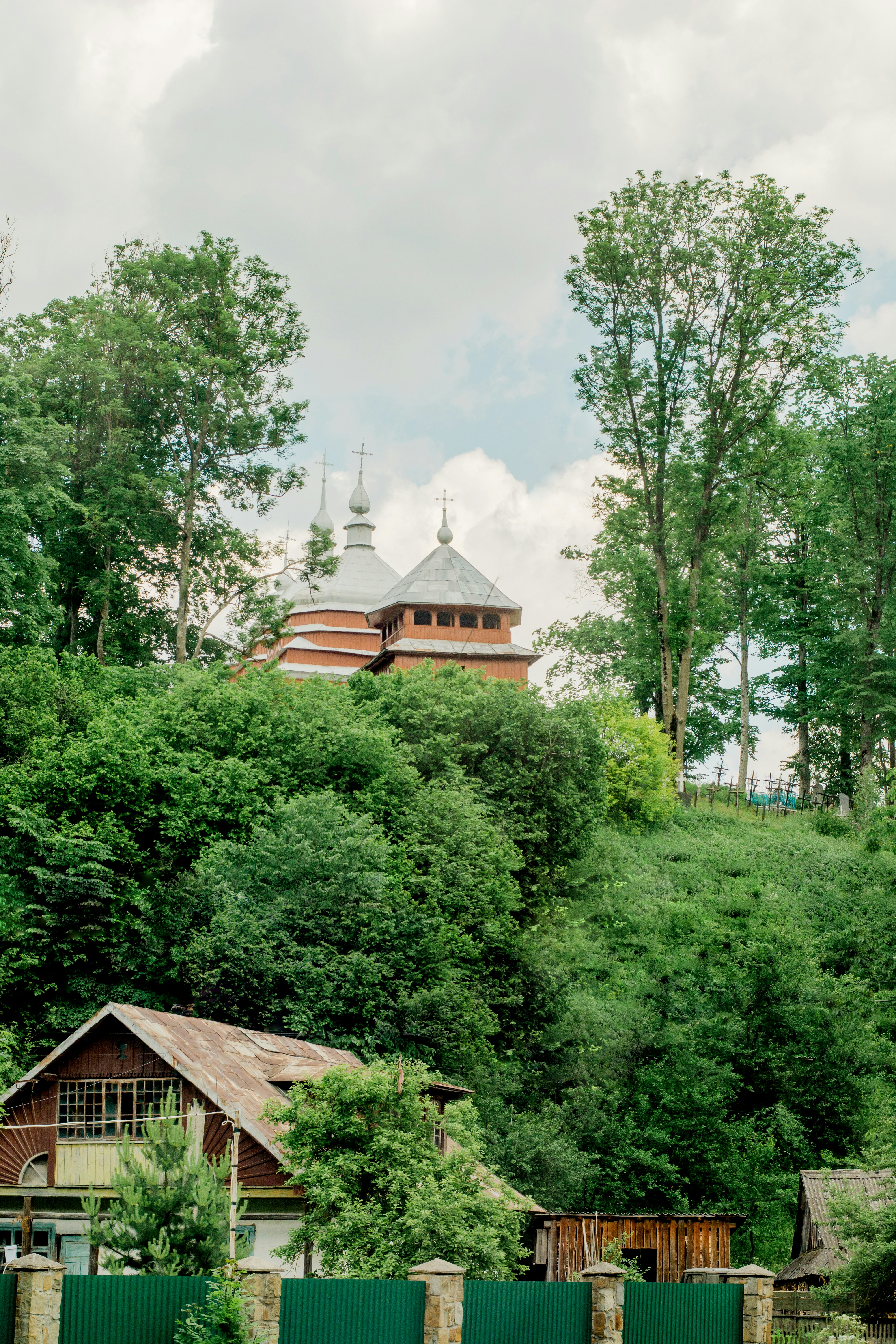 Hilltop Orthodox Church Crowned by Silver Domes Amid Lush Pines