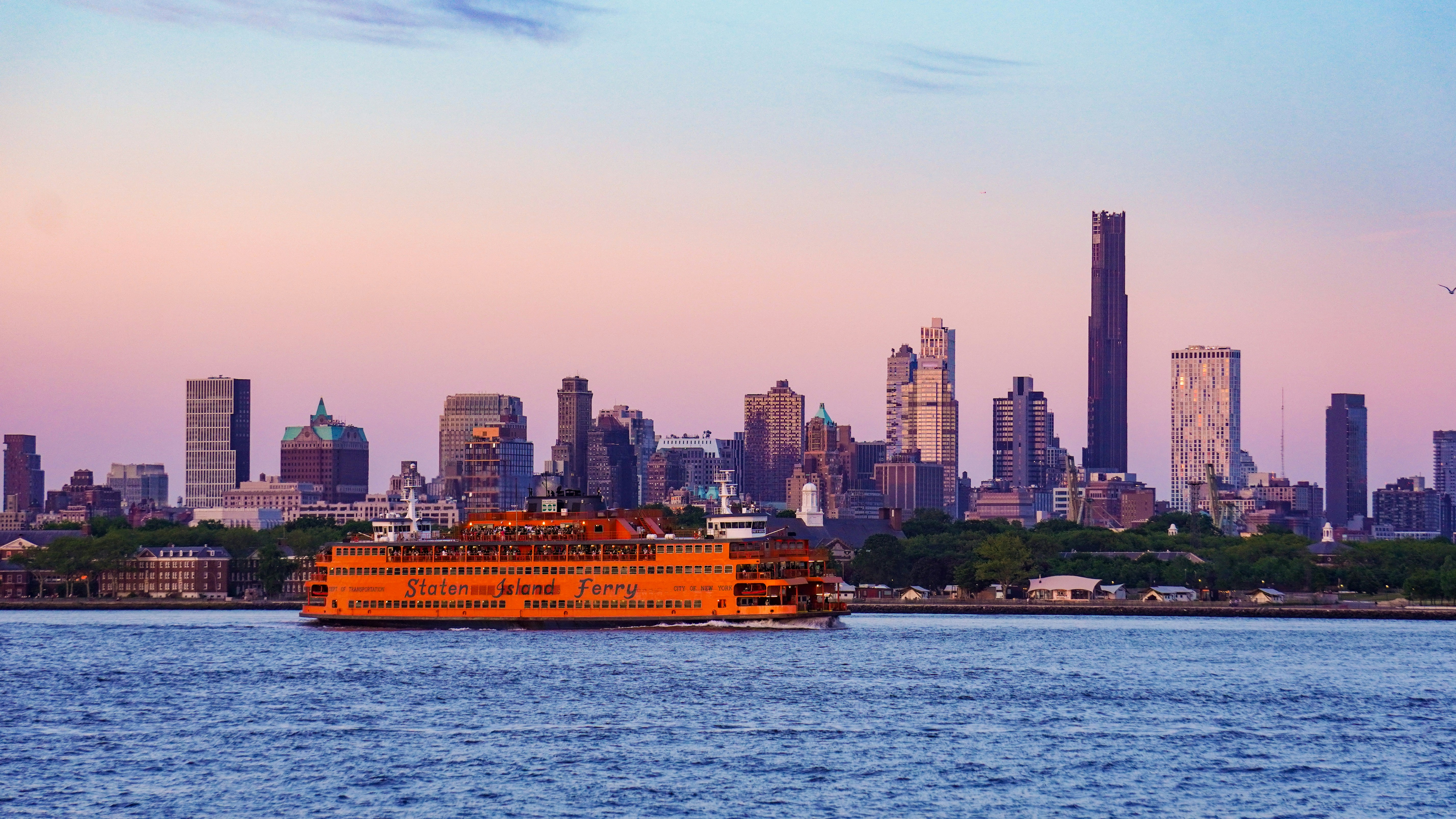 Orange Ferry at Sunset over City Skyline