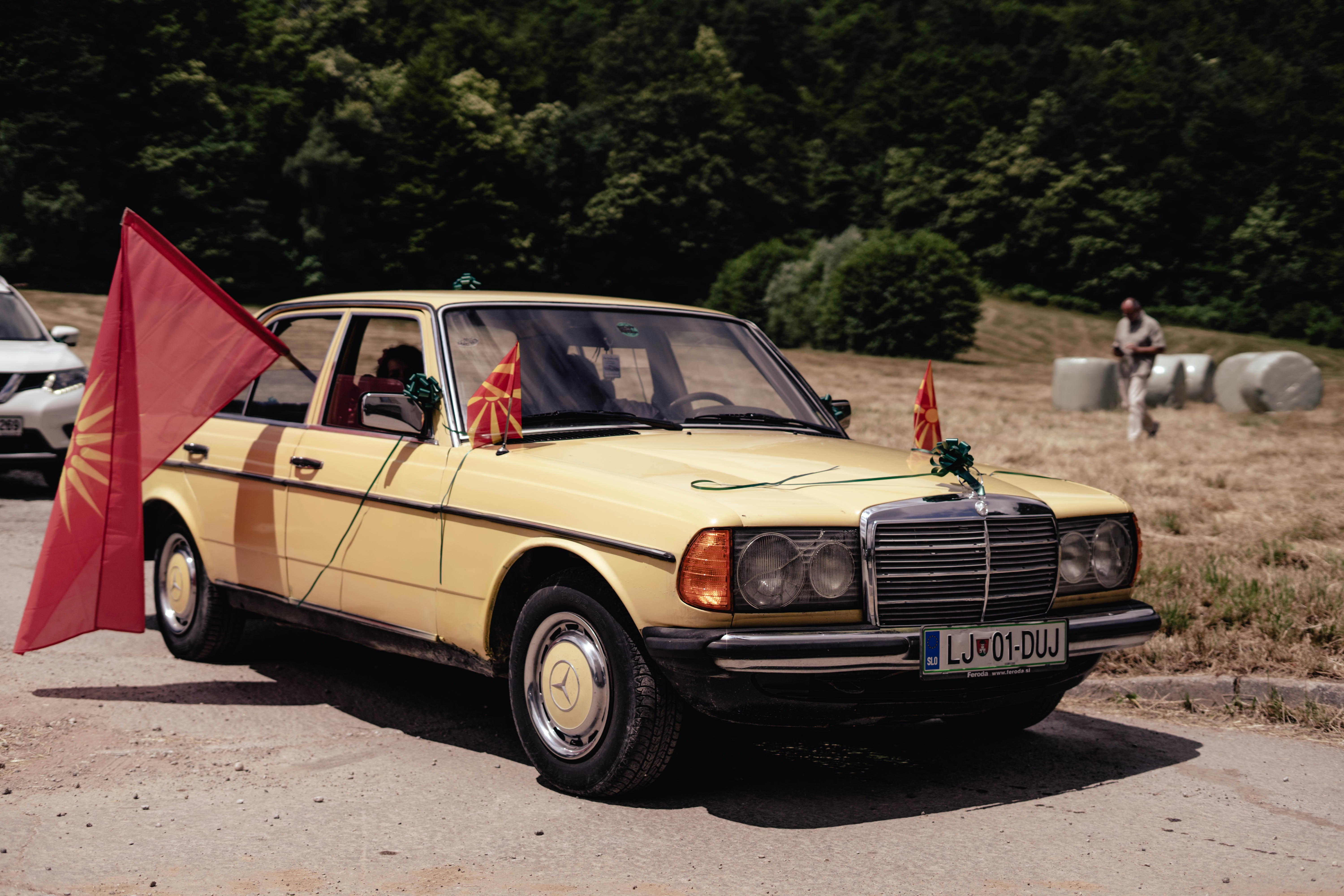 Flagged Yellow Classic: A 1980s Mercedes Graces a Sunlit Open Lot