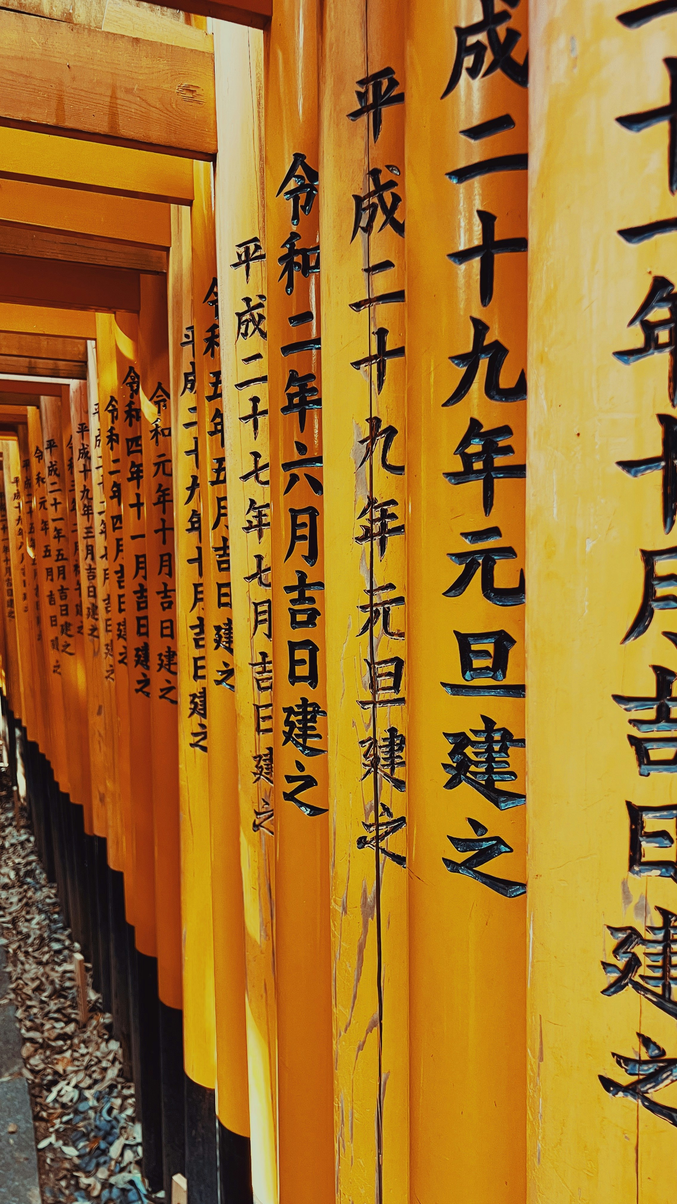 A series of vibrant orange torii gates adorned with inscriptions, creating a mesmerizing corridor that invites exploration. The gates symbolize the passage between the mundane and the sacred.