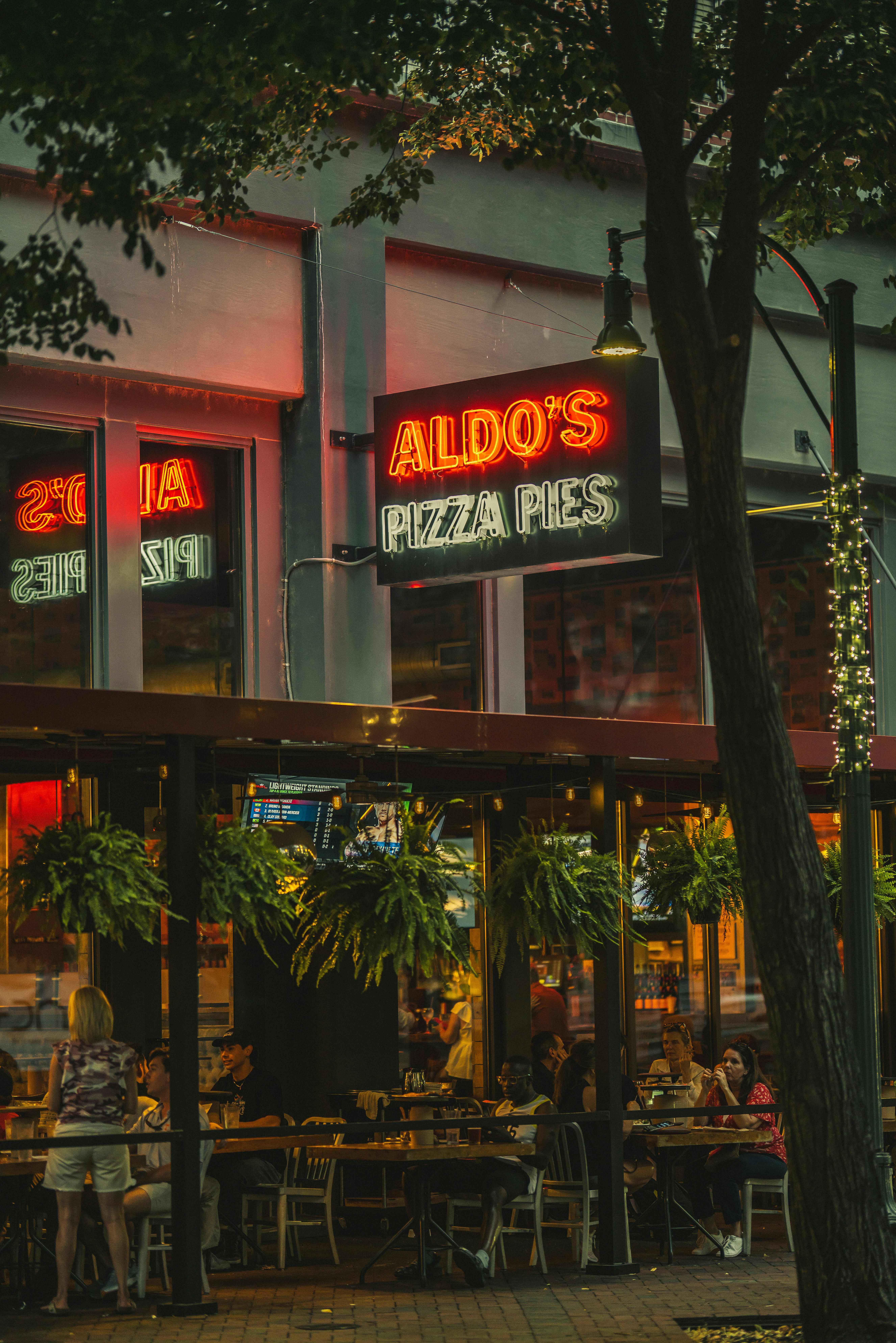 A restaurant called aldos pizza pies is lit up at night photo – Free ...