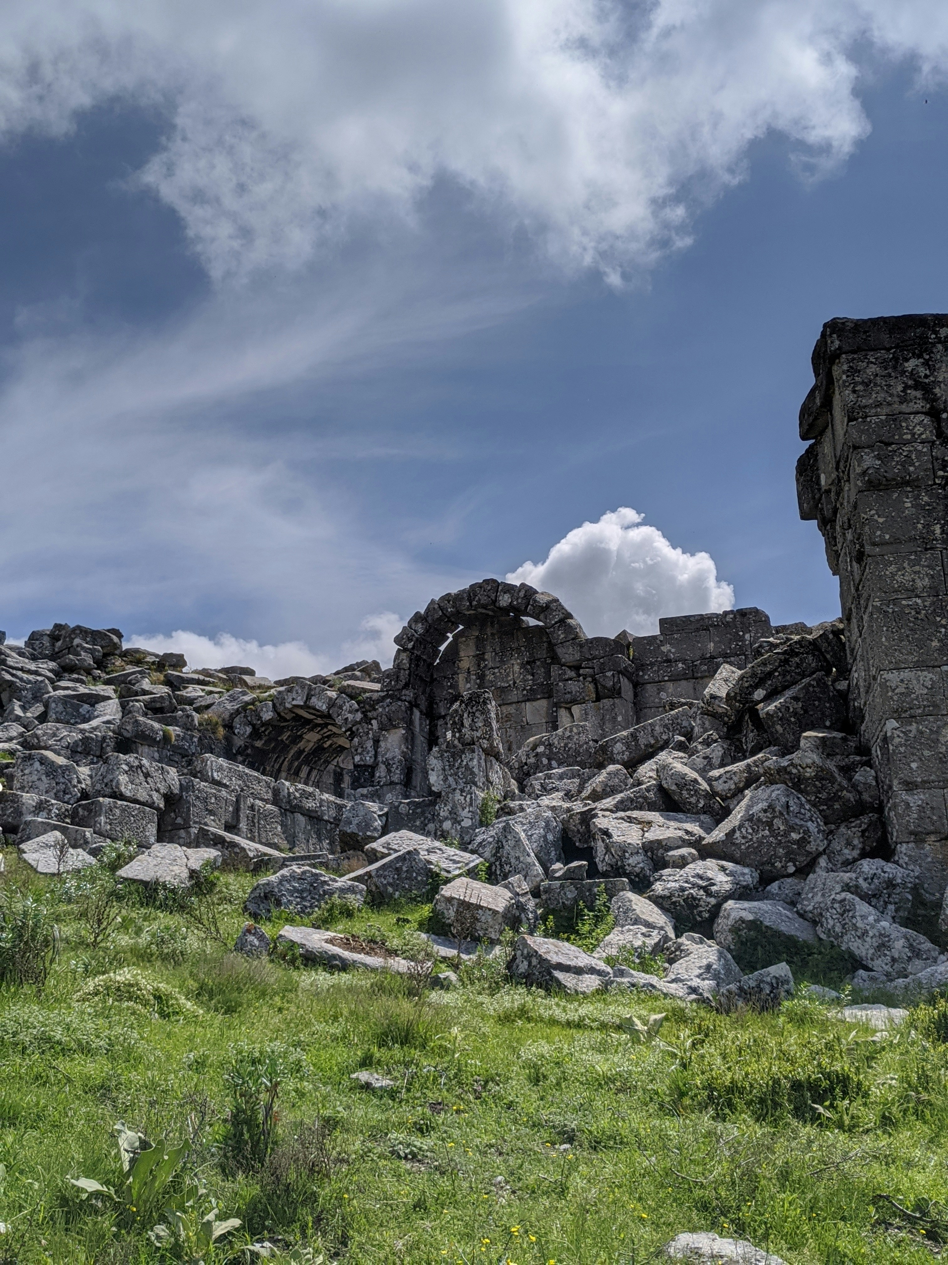 A large rock structure sitting on top of a lush green field photo ...