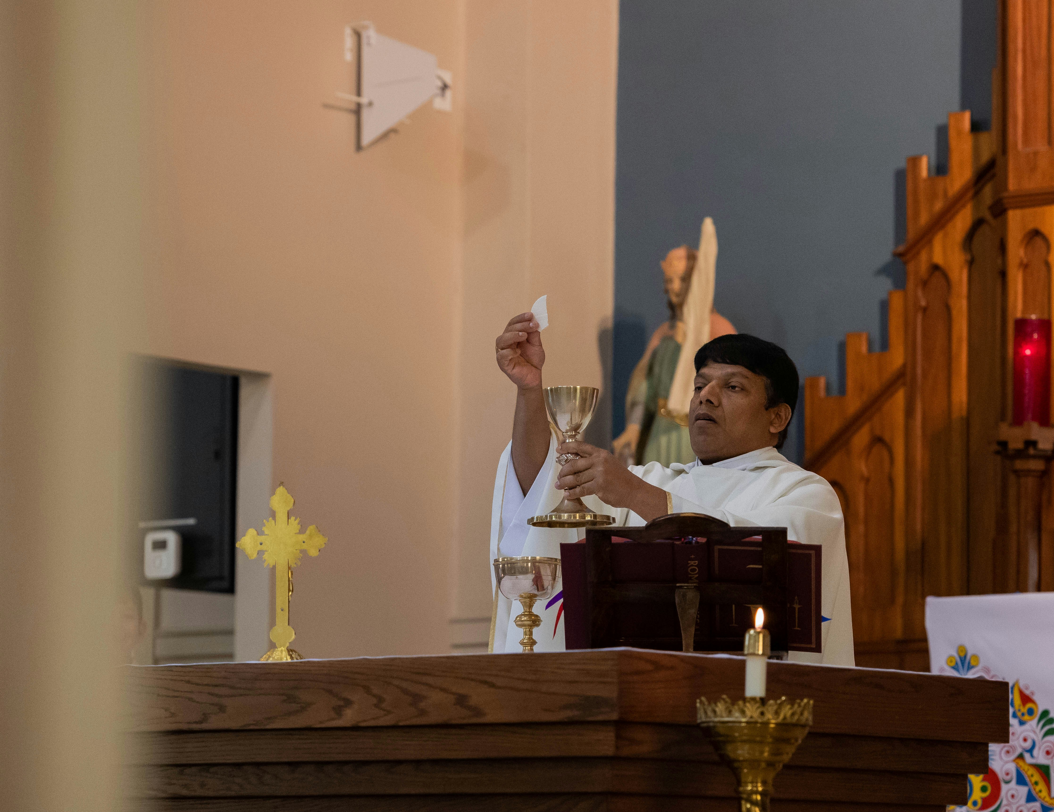 A priest holding a glass of wine in a church photo – Free Prayer Image ...