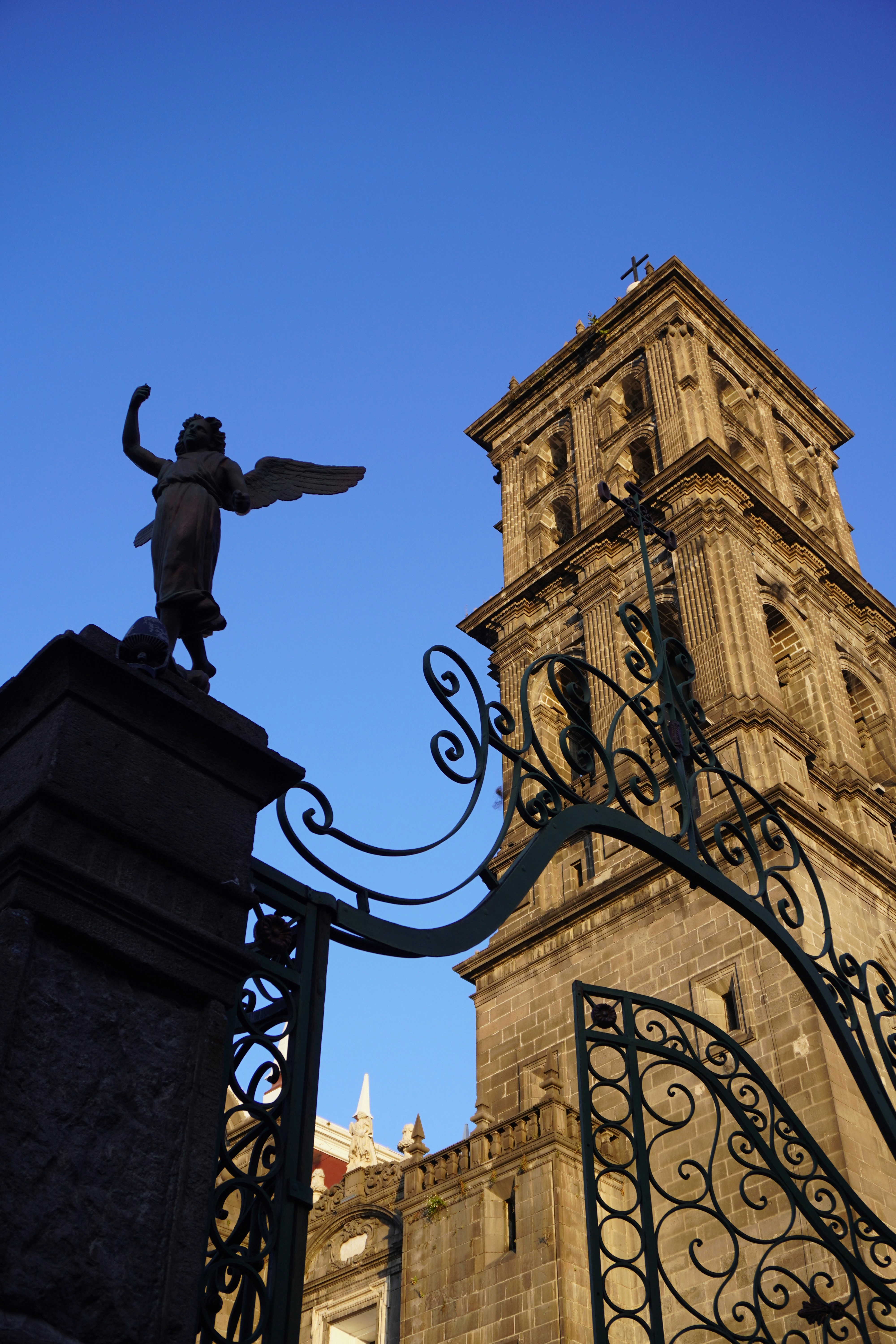 Angel Over Arch: A Gothic Bell Tower Beneath a Cerulean Sky