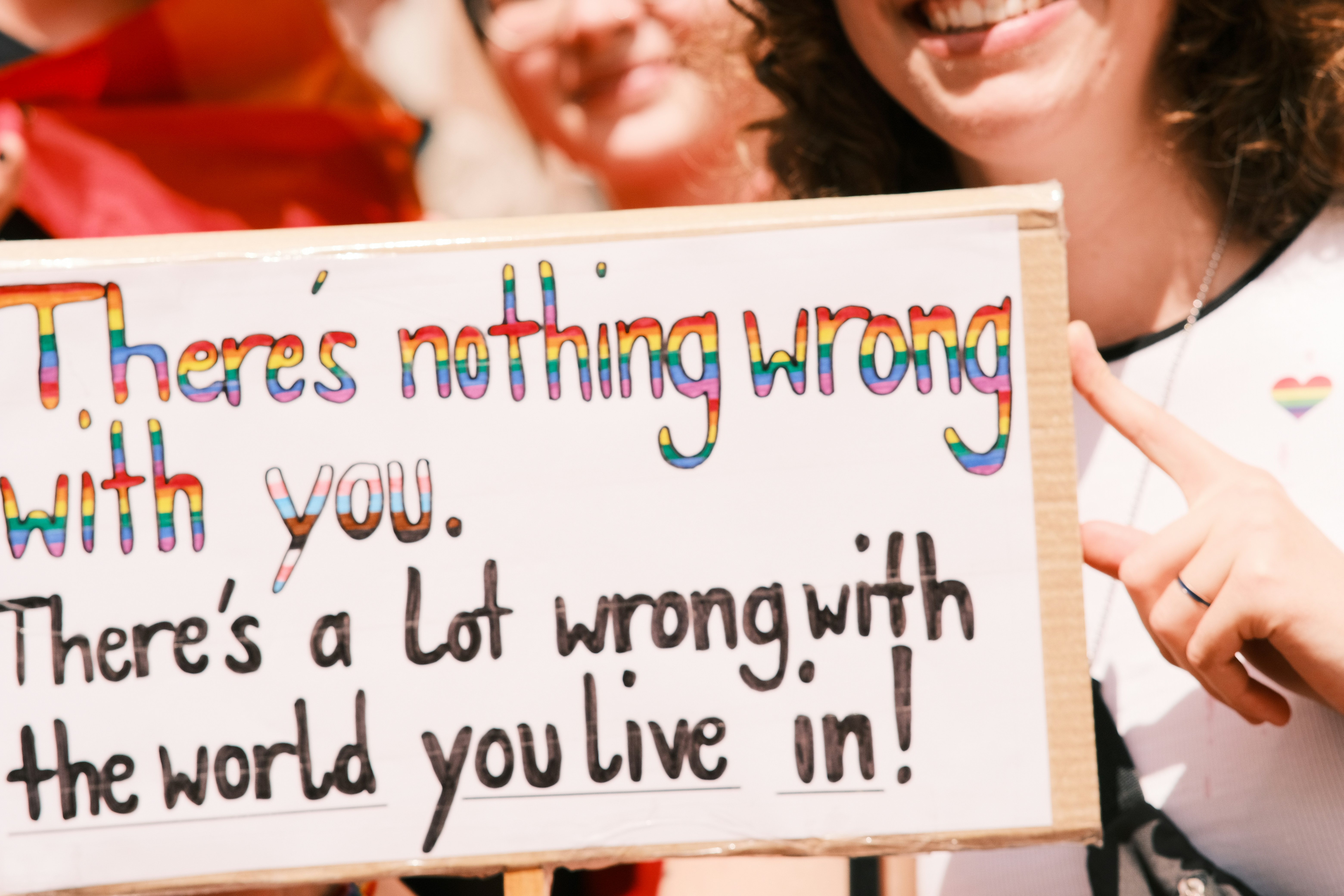 A woman holding a sign that says there's nothing wrong with you photo ...