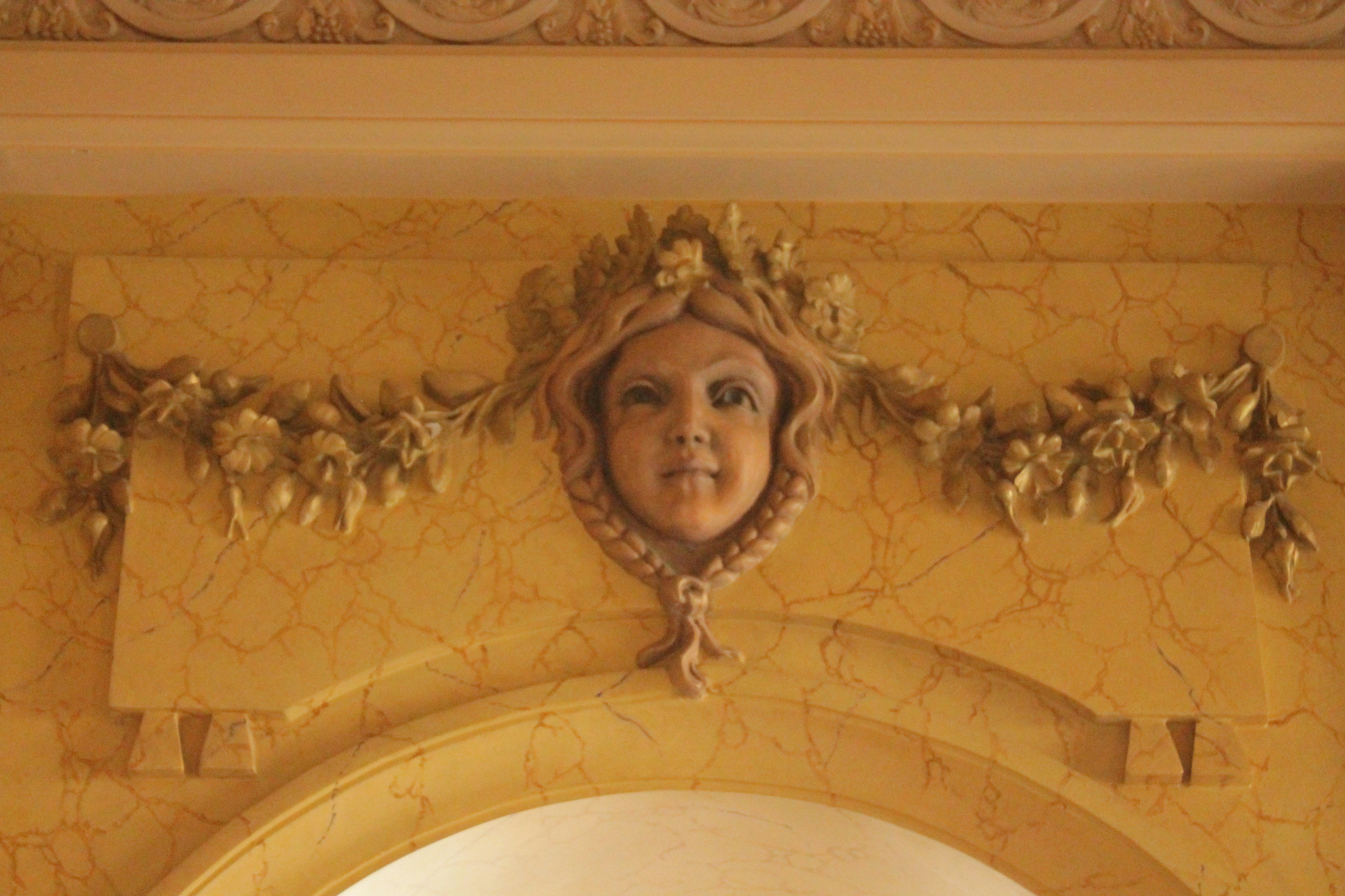 Gilded Crest Above the Mirror: A Central Carved Bust Framed by Laurel Garlands