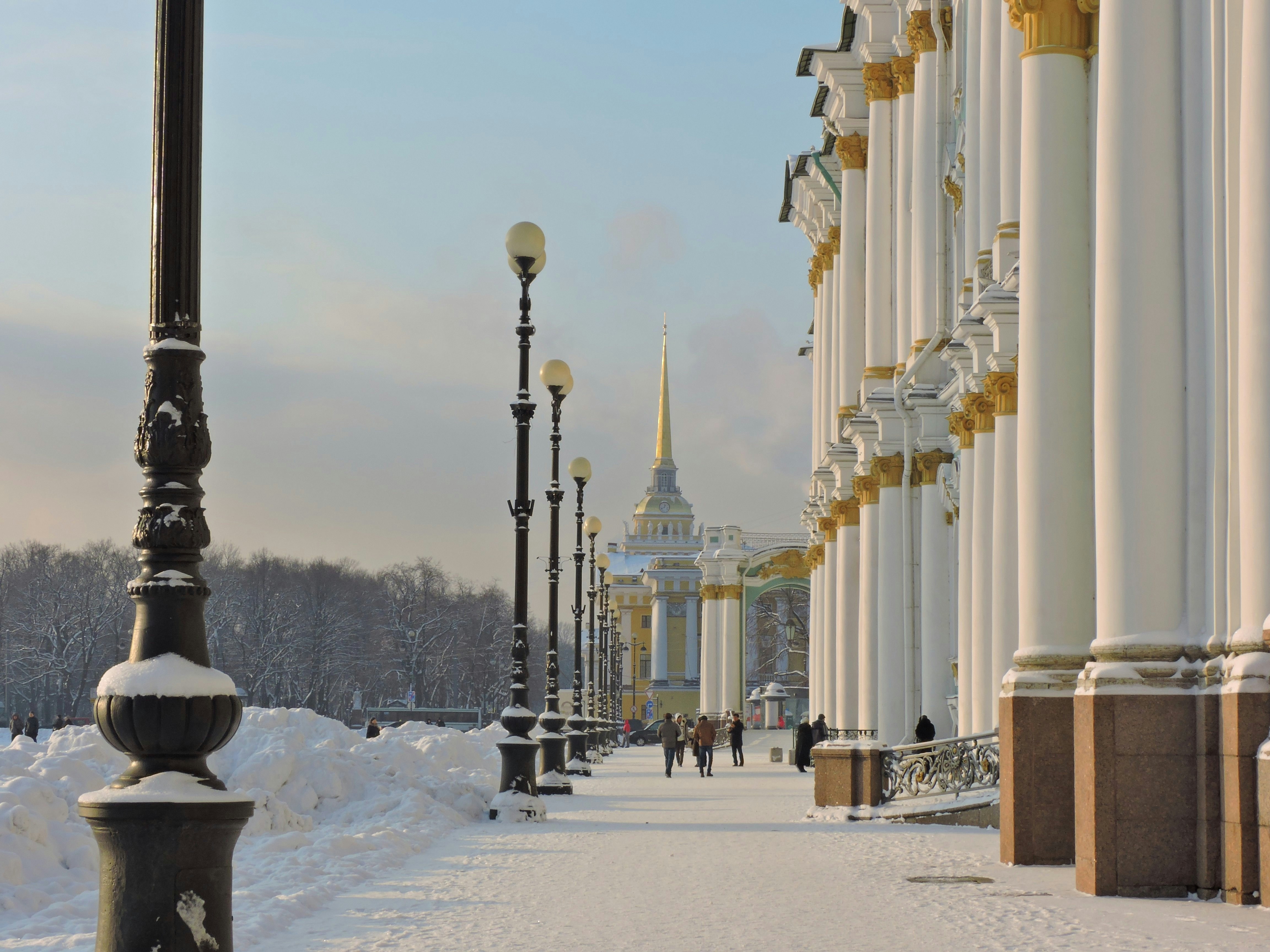 Snowy promenade under a columned arcade leading to a distant gilded spire