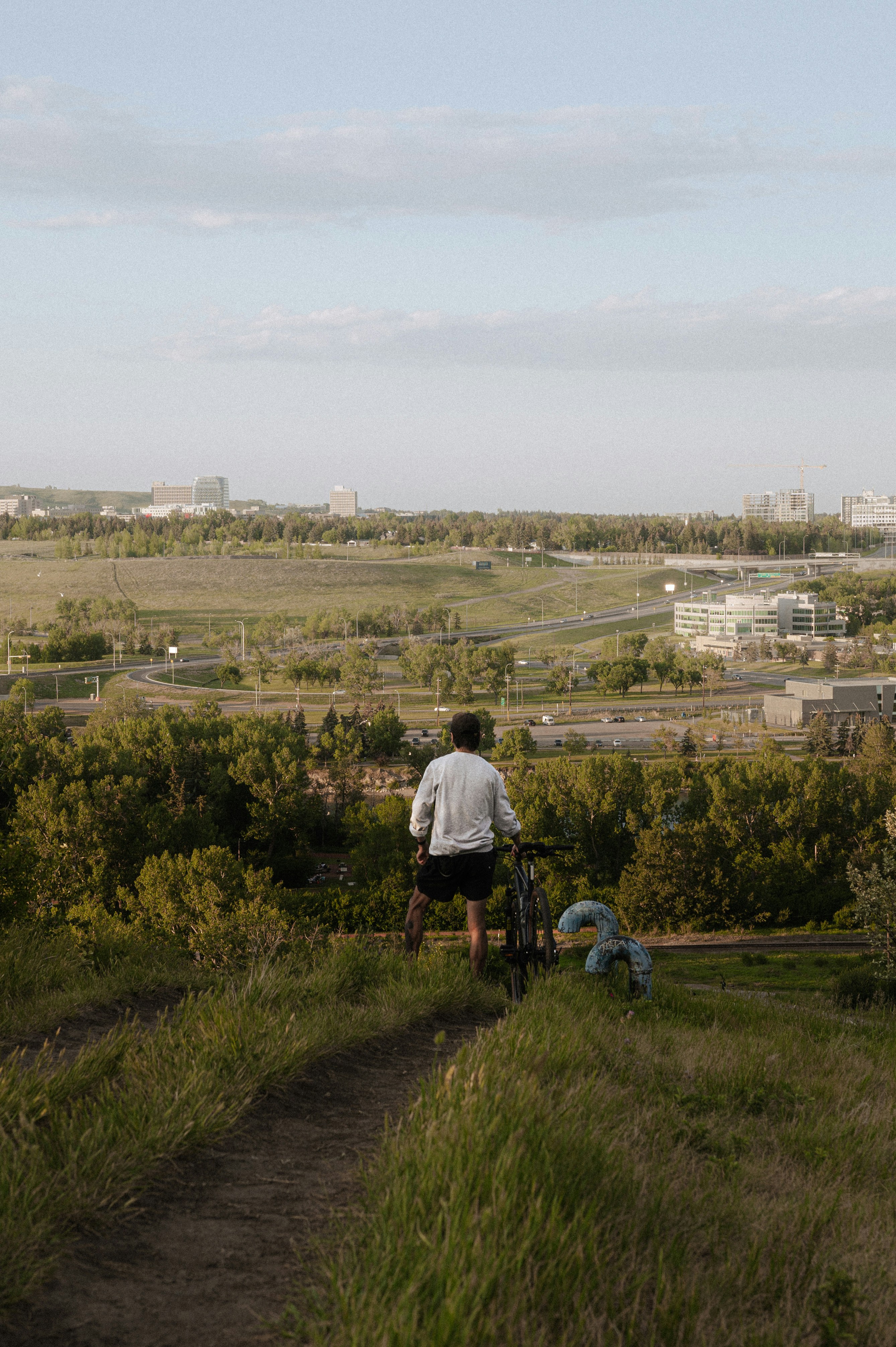 Hilltop Pause: A Lone Rider and the City’s Winding Ribbon