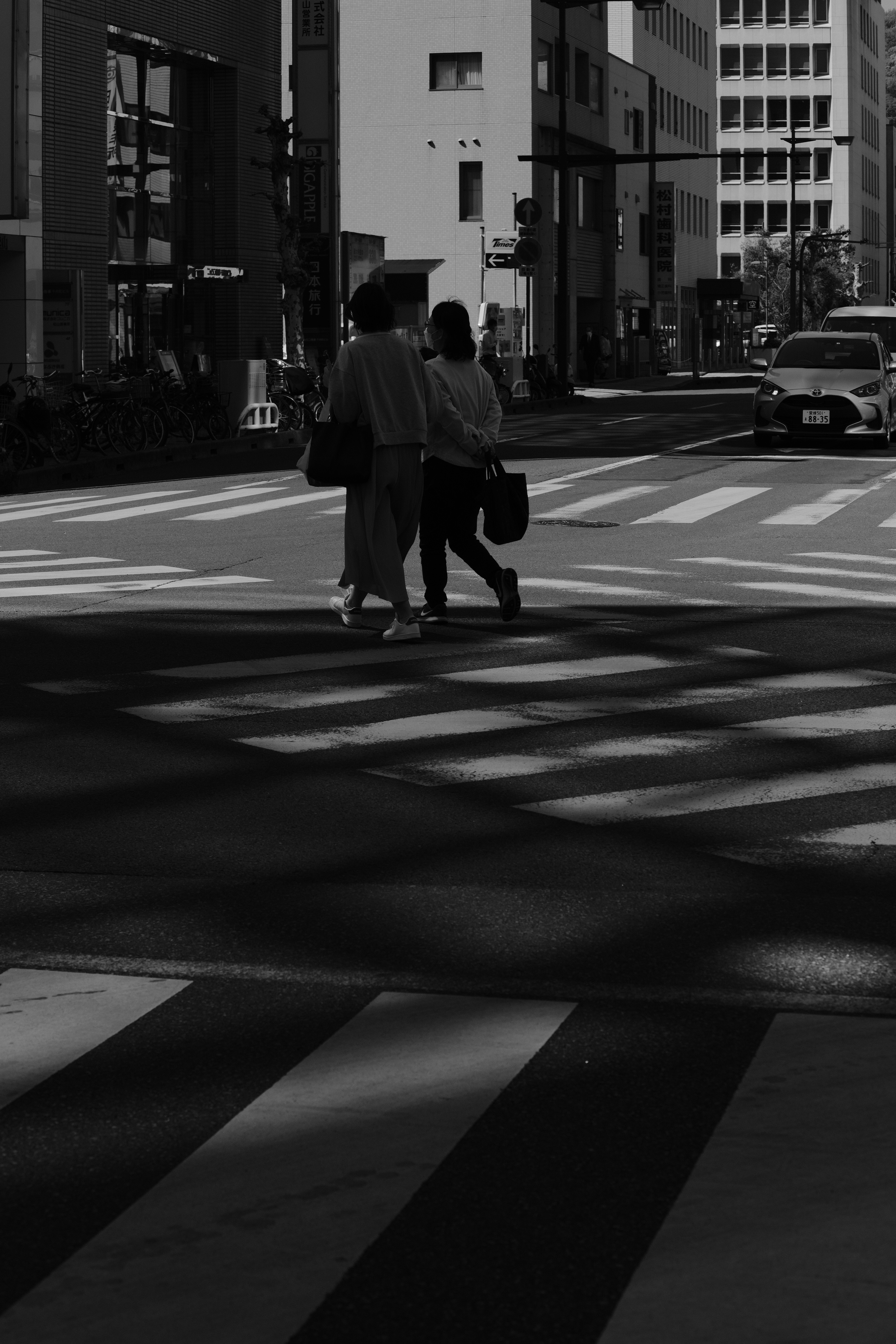 A black and white photo of two people crossing the street photo – Free ...