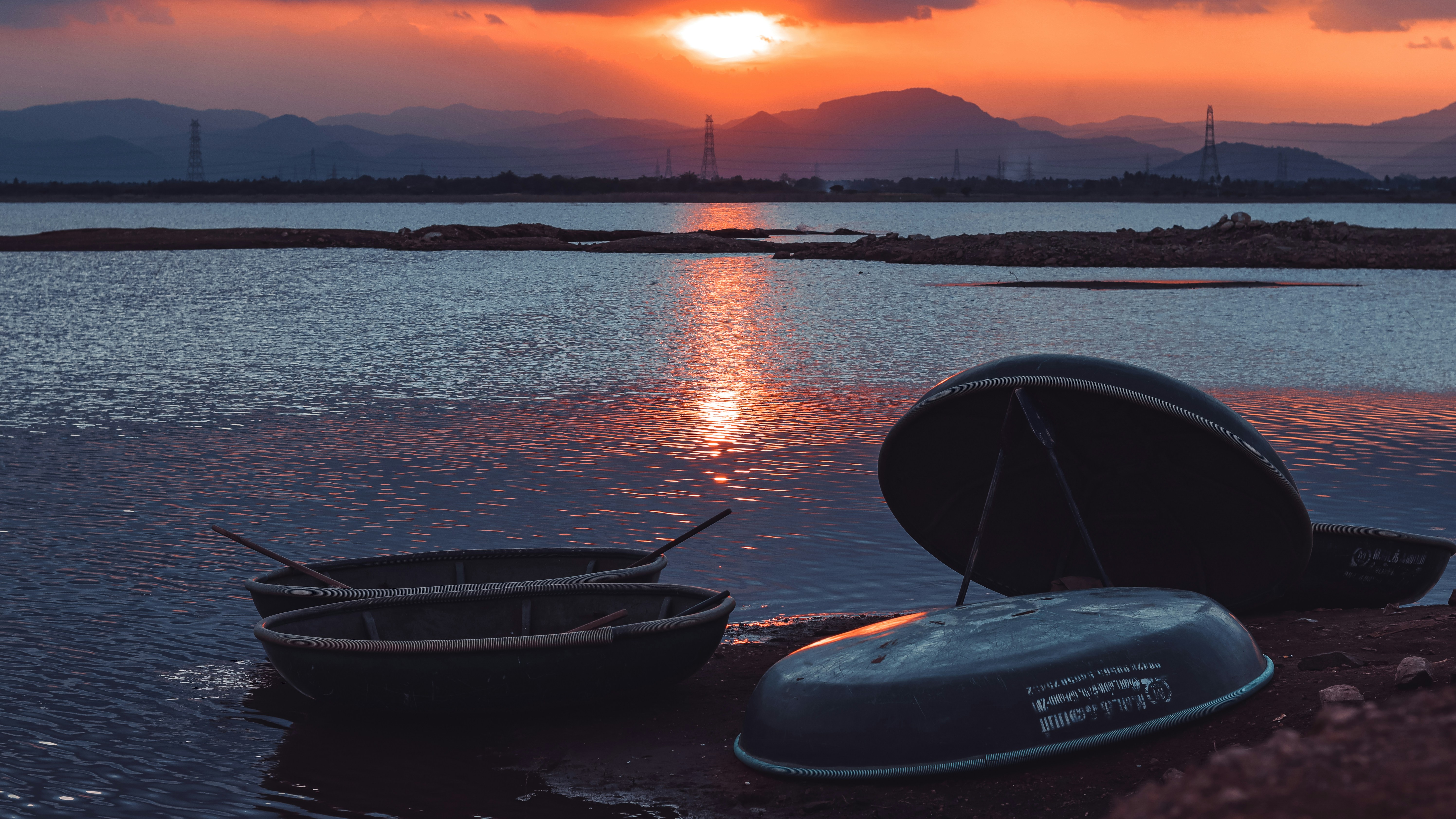 a boat sitting on top of a lake next to a body of water