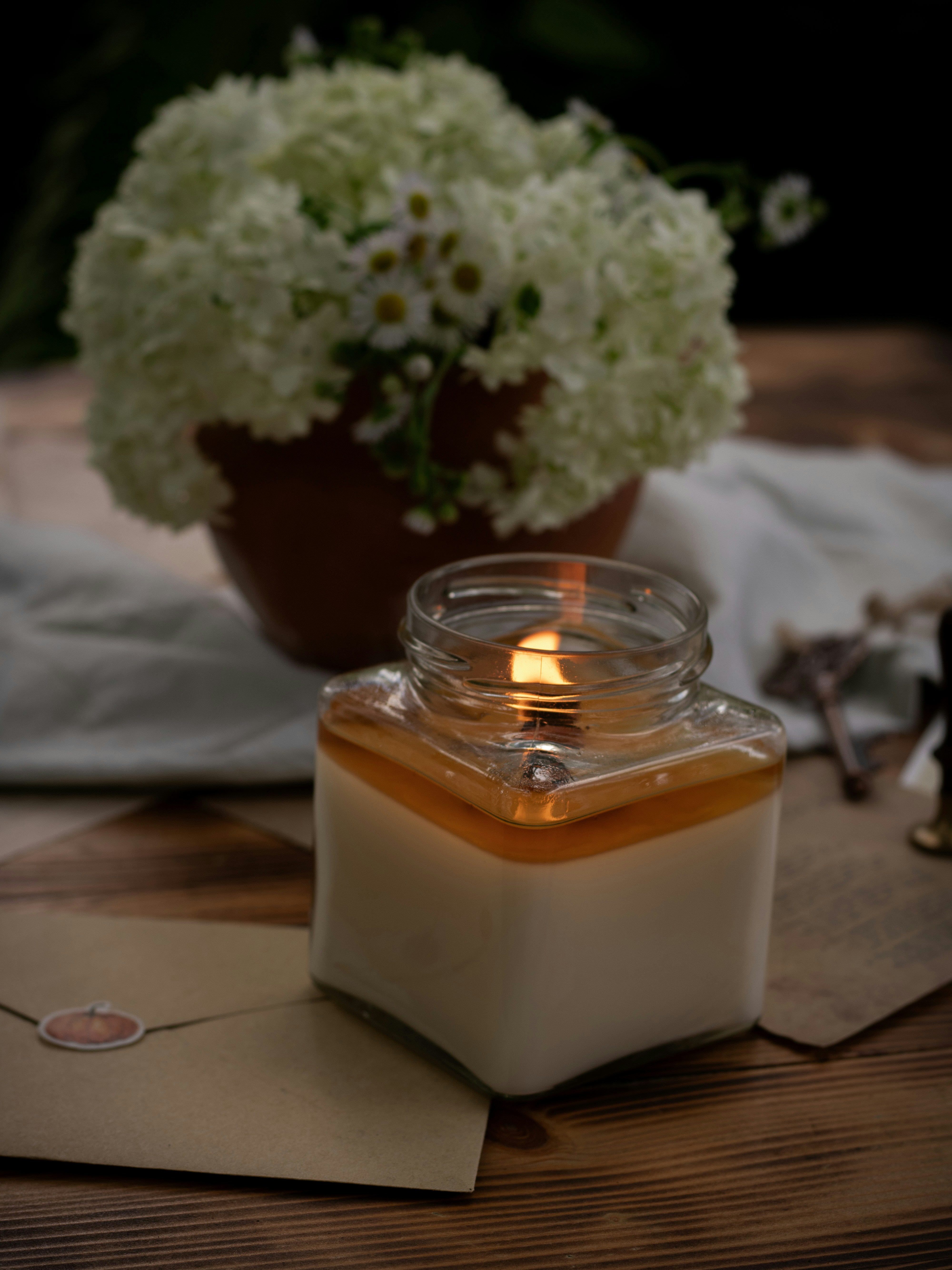 Warm Glow on a Quiet Desk: A Candle, Floral Still Life