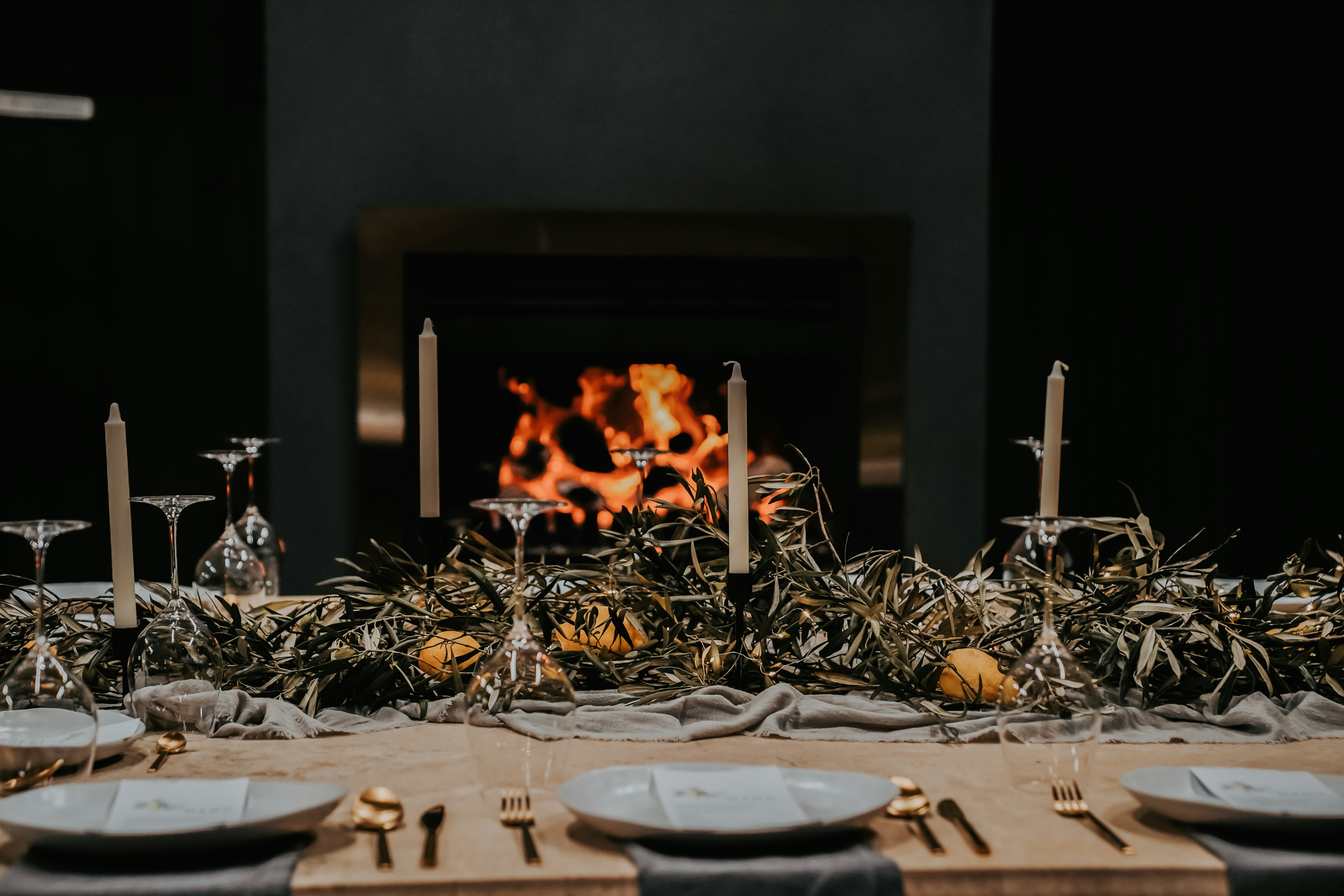 Hearthside Tablescape: Olive Garland, Candlelight, and a Fireplace Glow