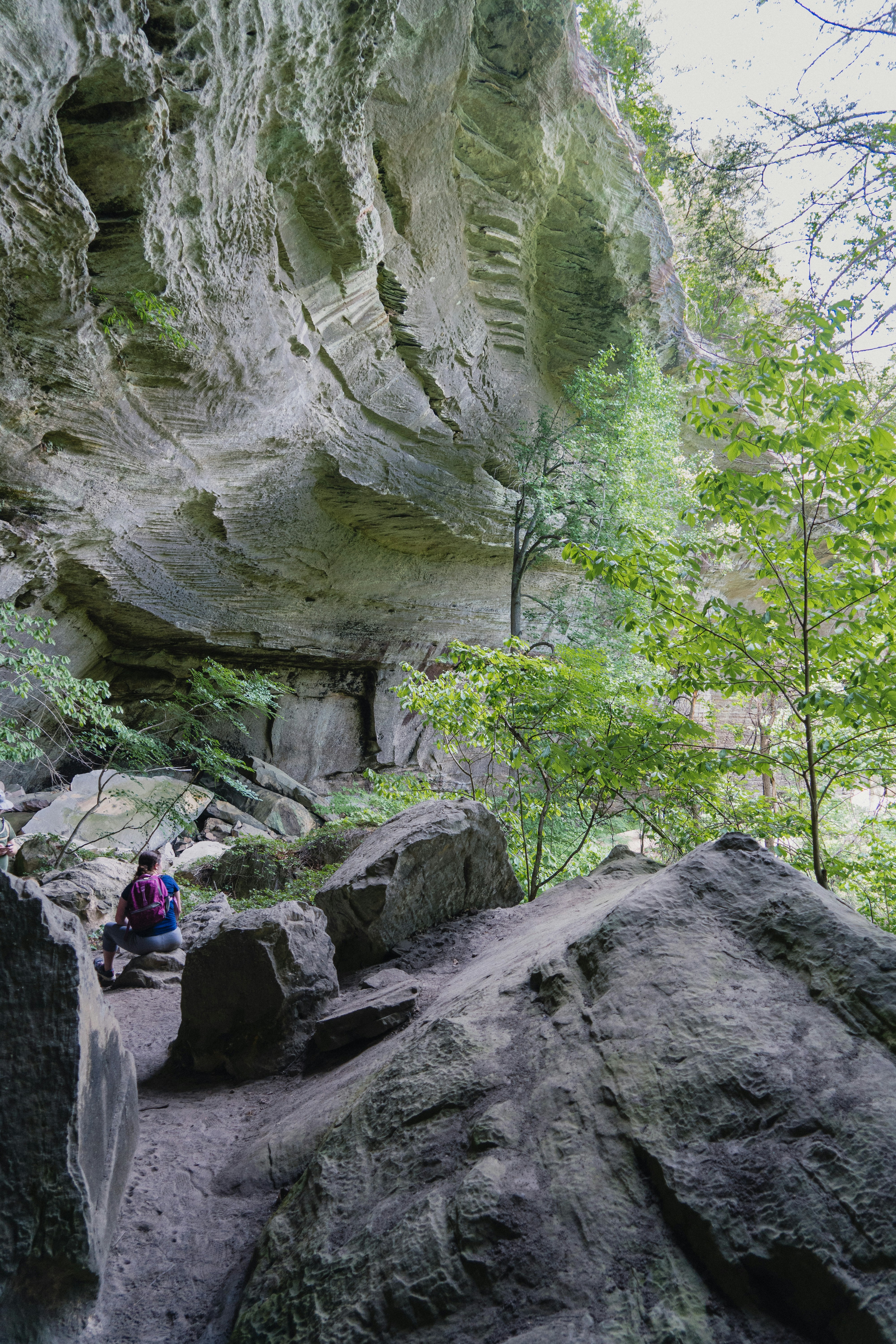 Resting Among Striated Cliffs: A Hiker's Quiet Pause in a Limestone Gorge