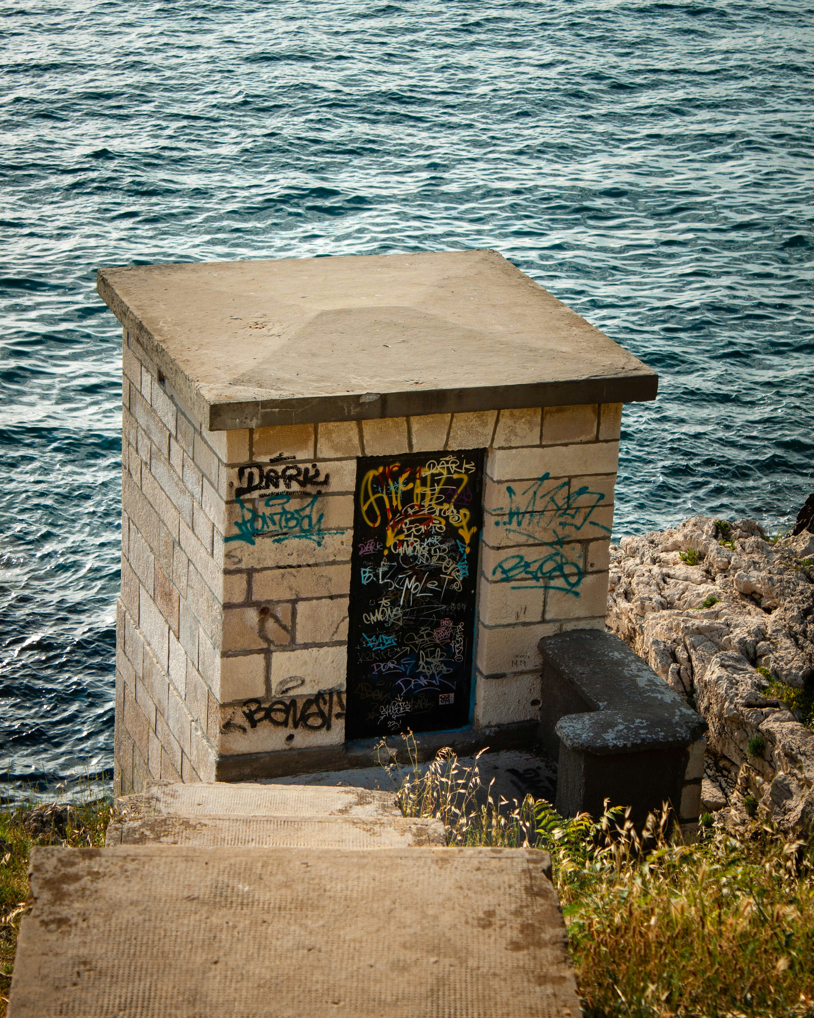 Seaside Graffiti Door Framed by Weathered Stone
