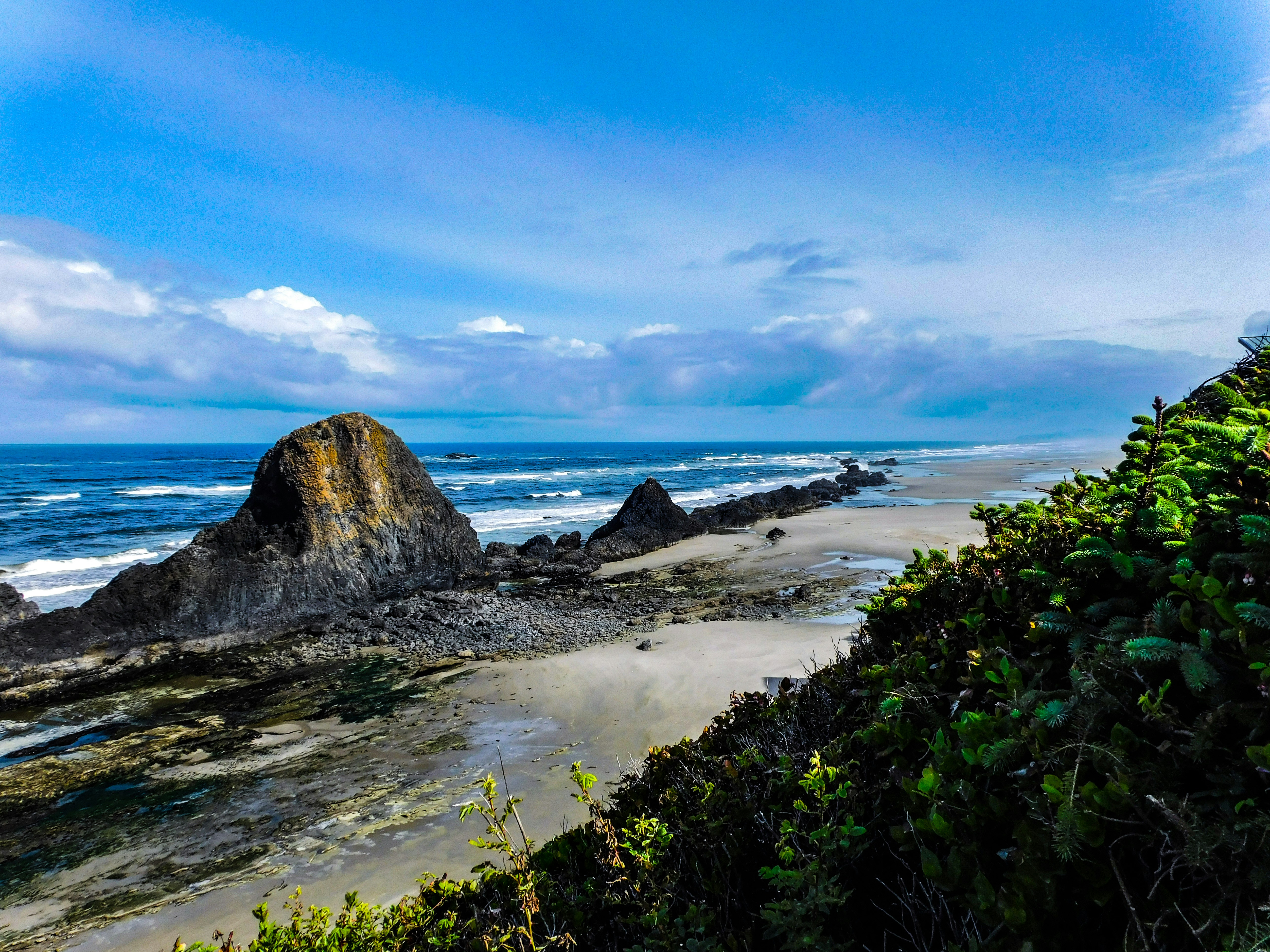 A view of a beach with a rock outcropping photo – Free Beach Image on ...