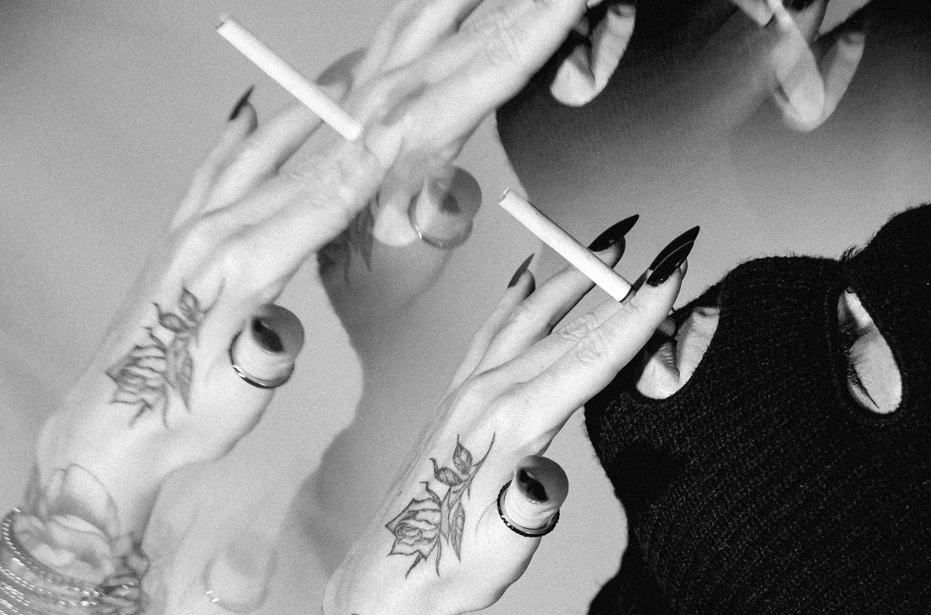 A couple of women holding cigarettes in their hands photo – Free Los ...