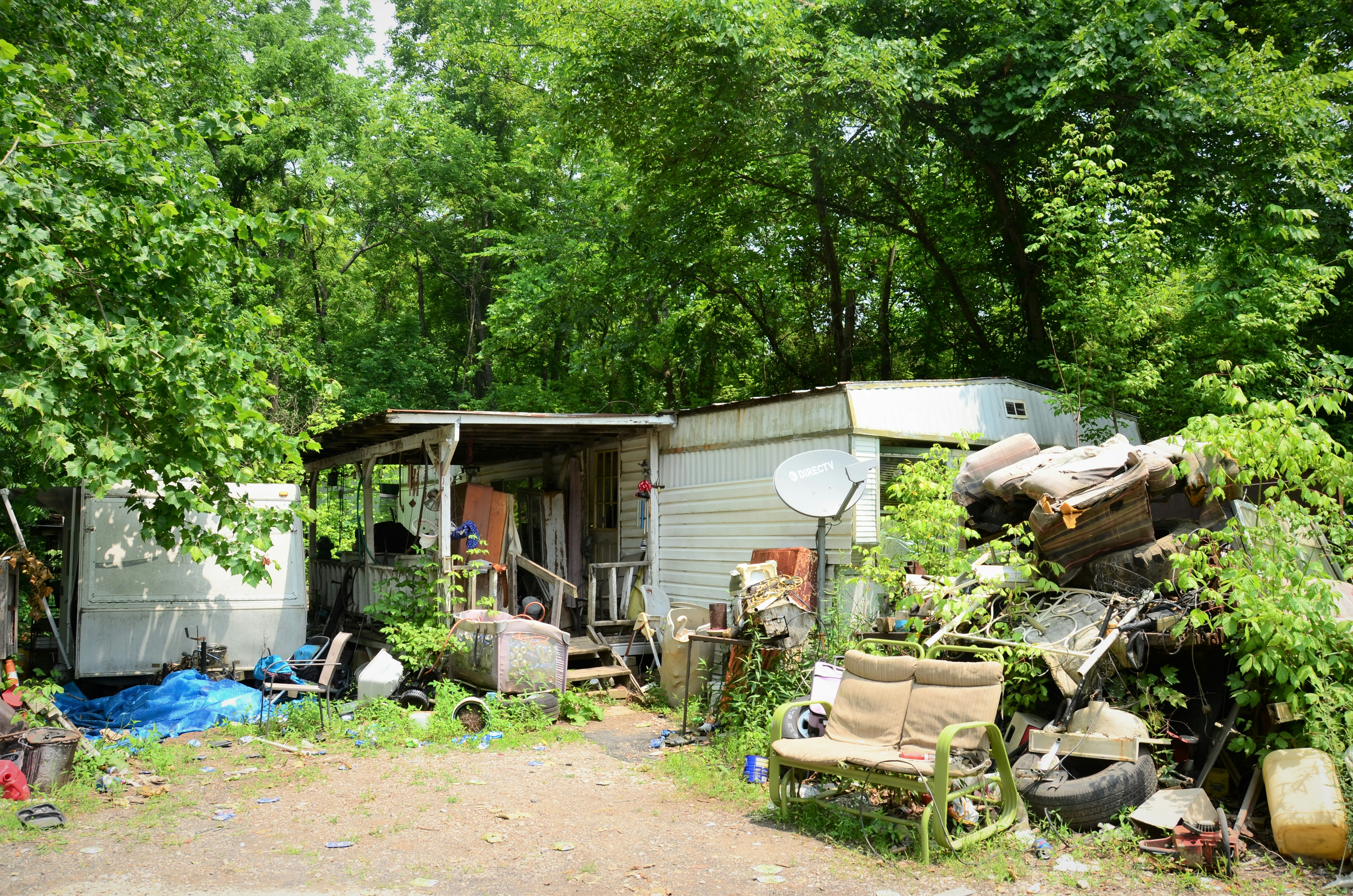A pile of junk sitting in the middle of a forest photo – Free House ...
