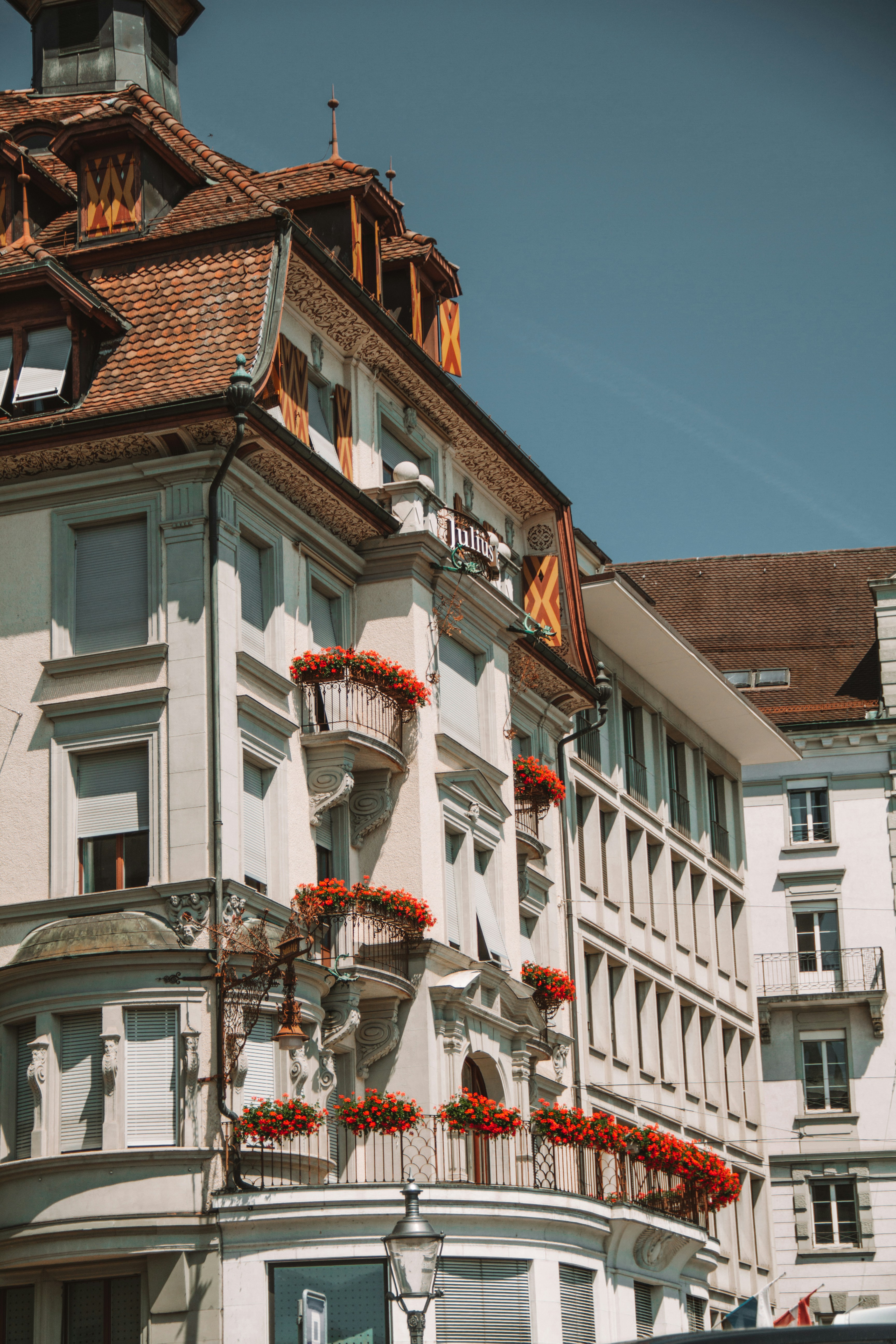 A tall white building with flowers on the balconies photo – Free City ...
