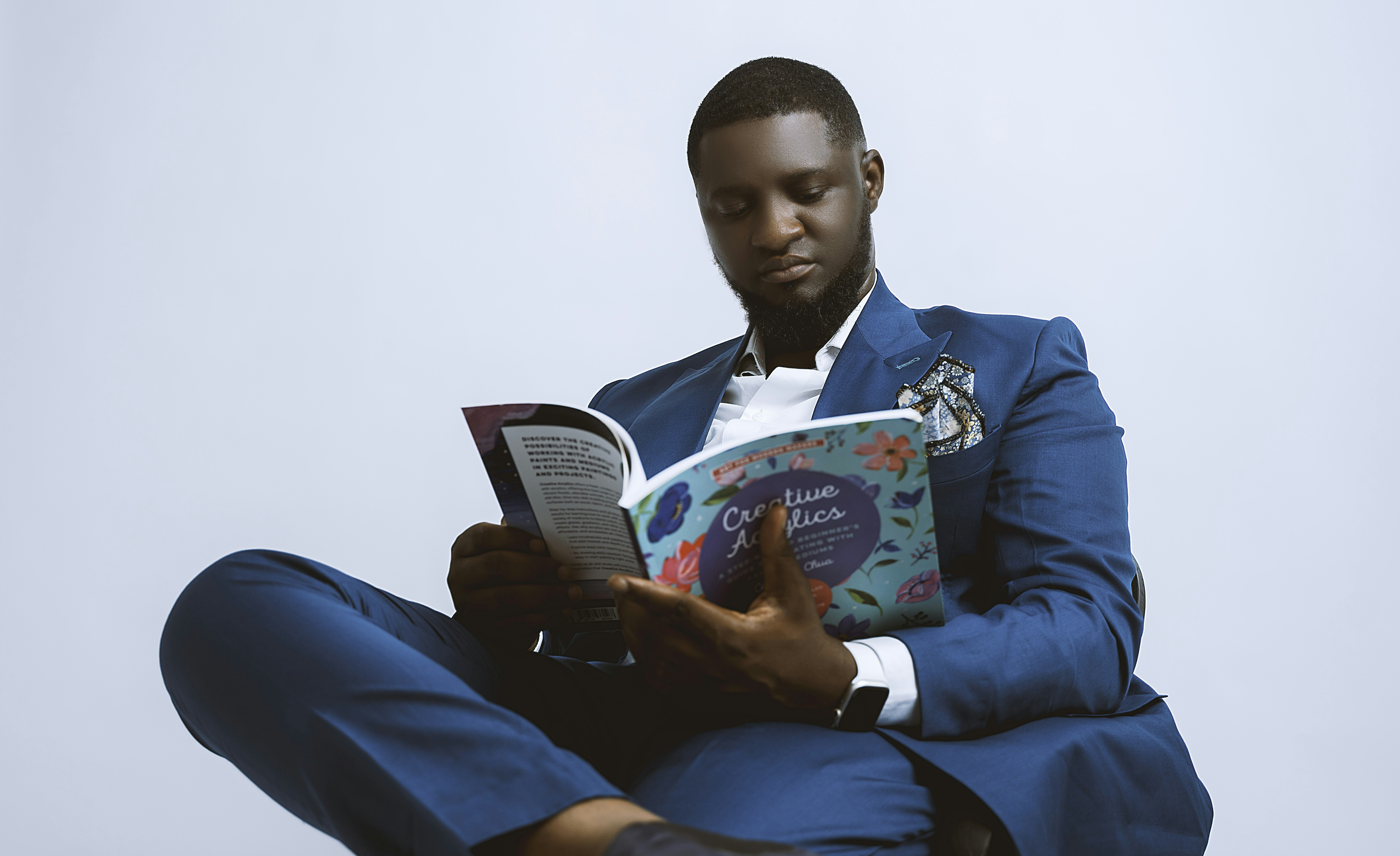 A man in a blue suit reading a book photo – Free Reading Image on Unsplash
