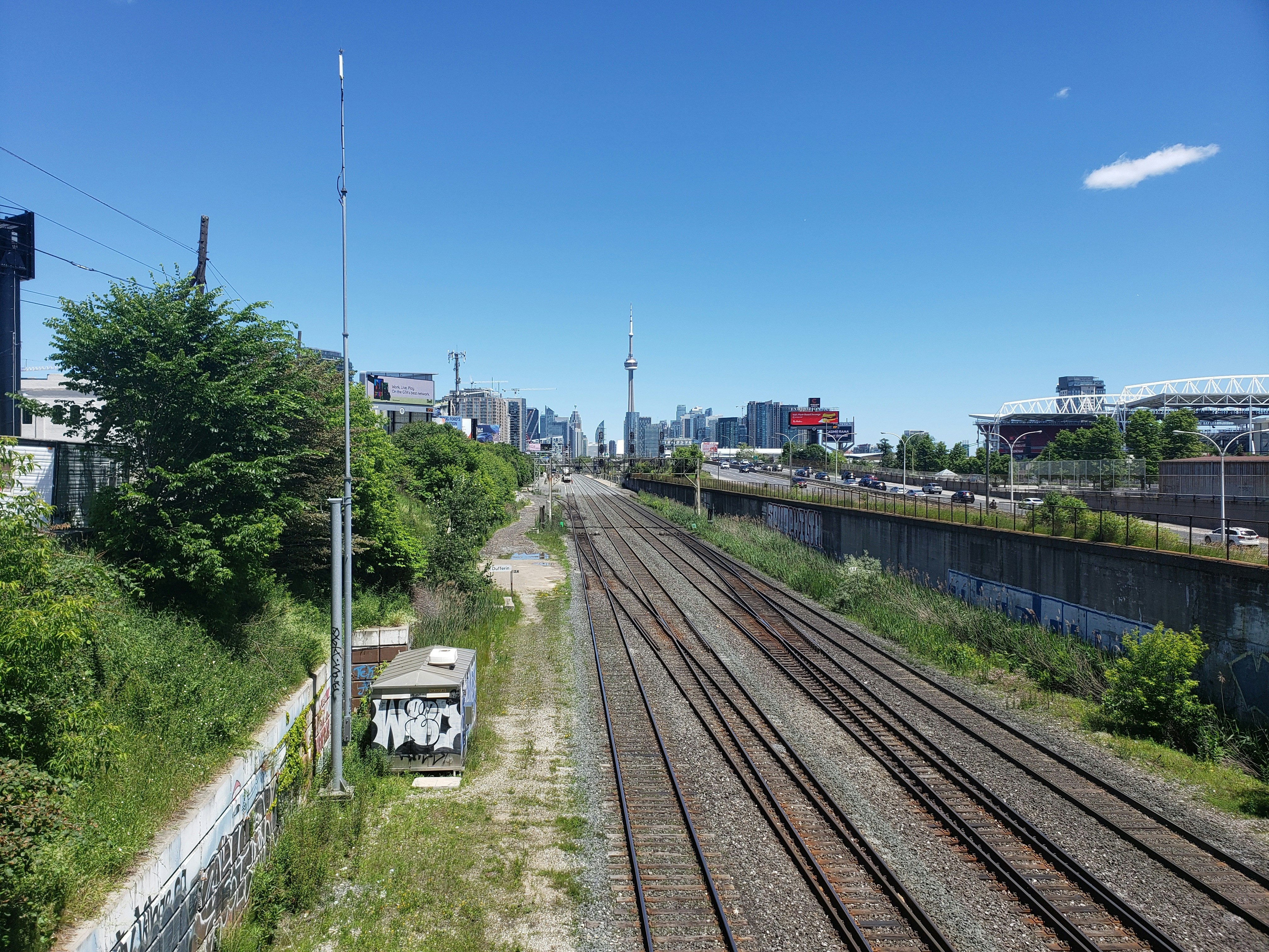 Converging Rails Toward a Blue-Sky Cityscape