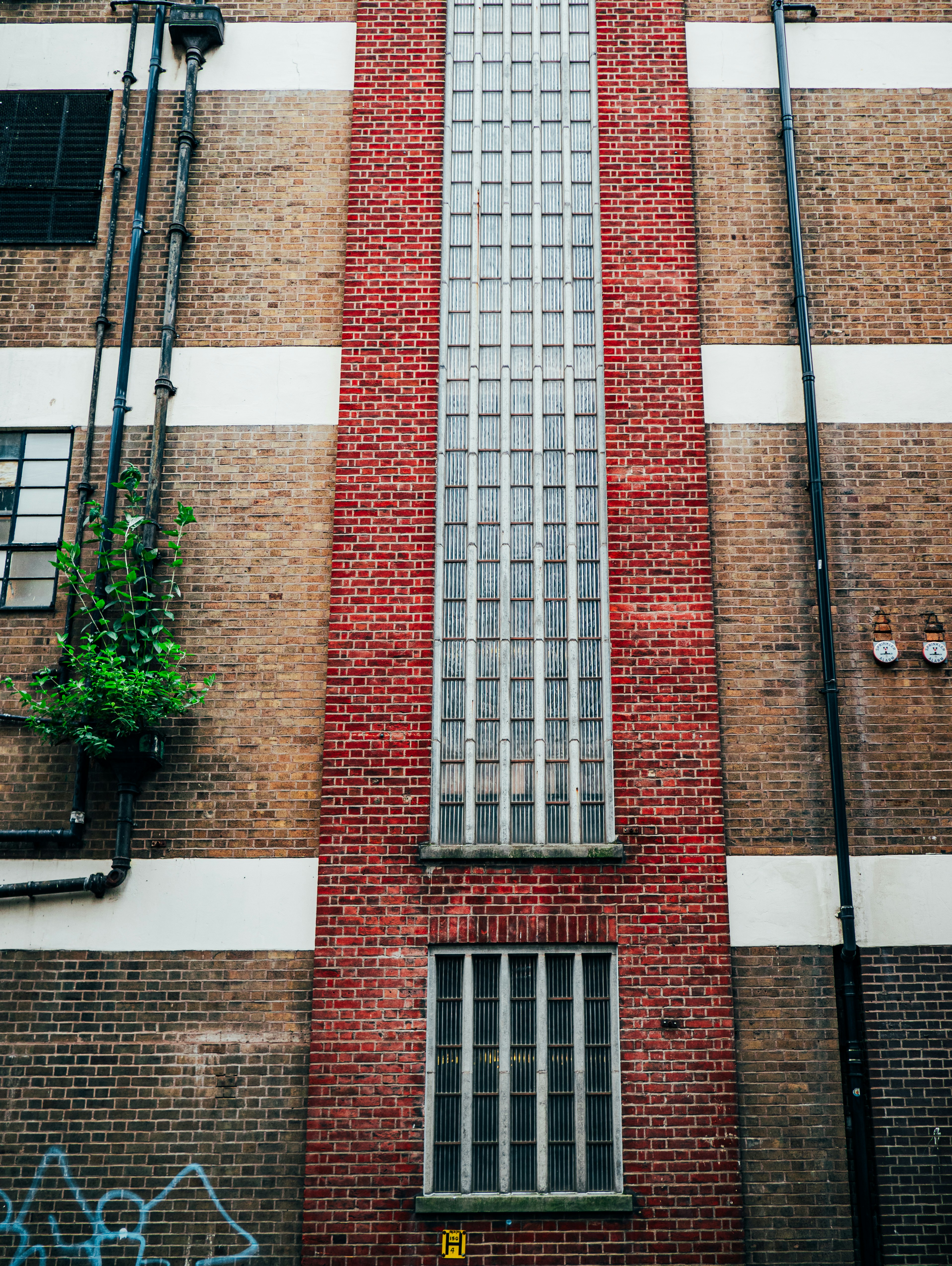 A tall red brick building with a window photo – Free Manchester Image ...