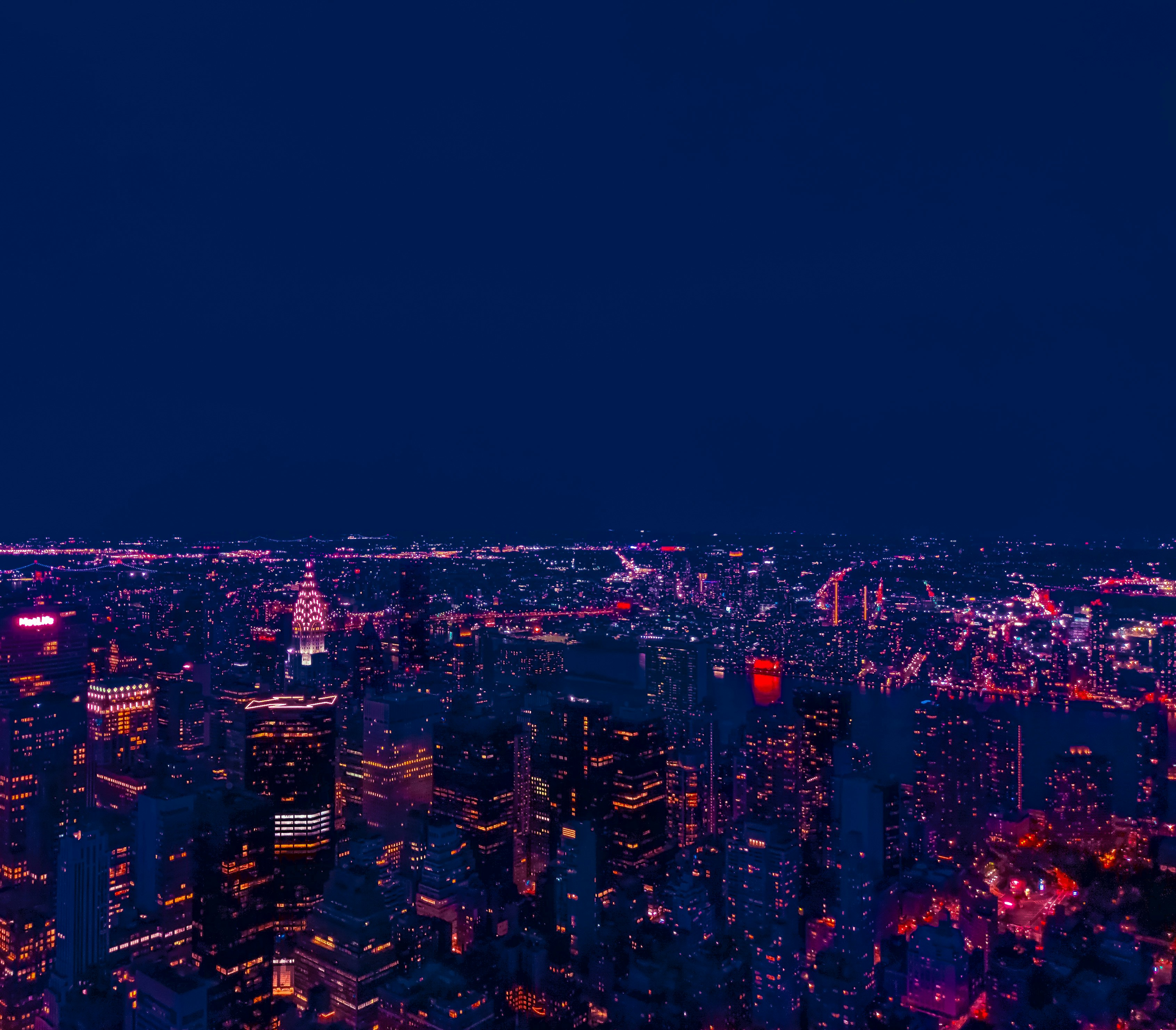 A view of a city at night from the top of a building photo – Free ...