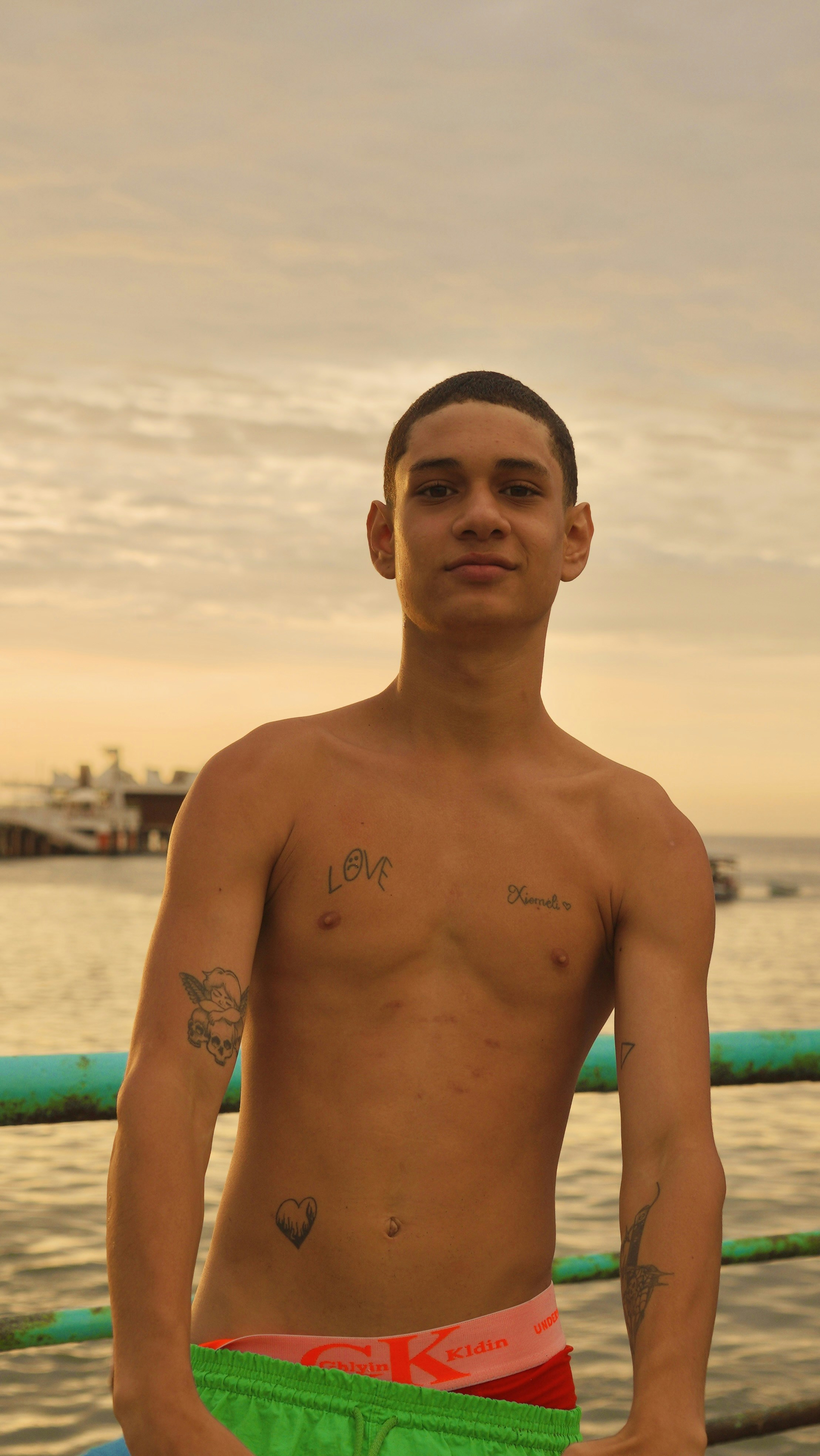 Golden Hour at the Pier: Tattooed Confidence by the Sunset Sea