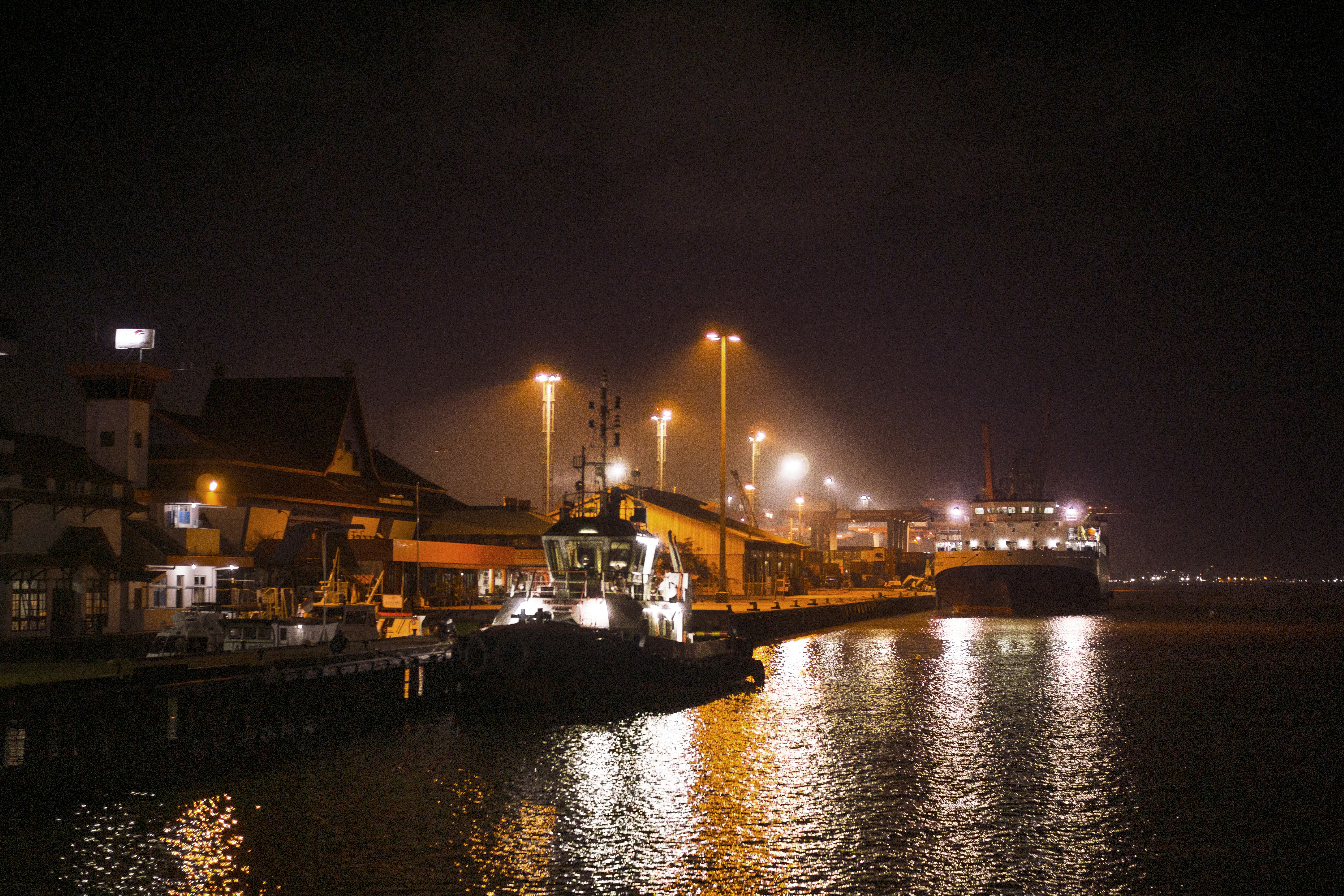 A night scene of a harbor with a large ship in the distance photo ...