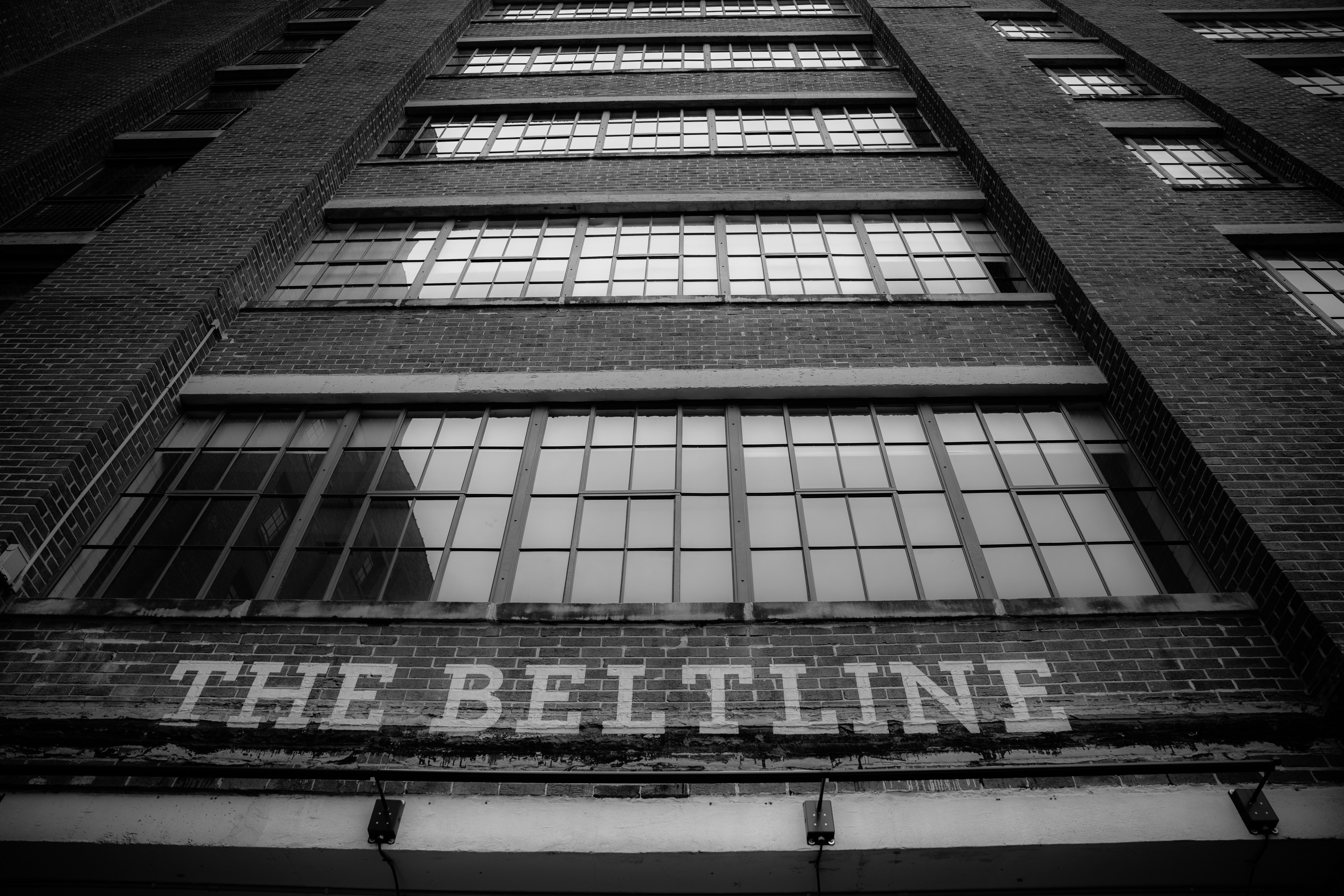Black and white photo of a multi-story brick building with large windows and 'The Beltline' sign.