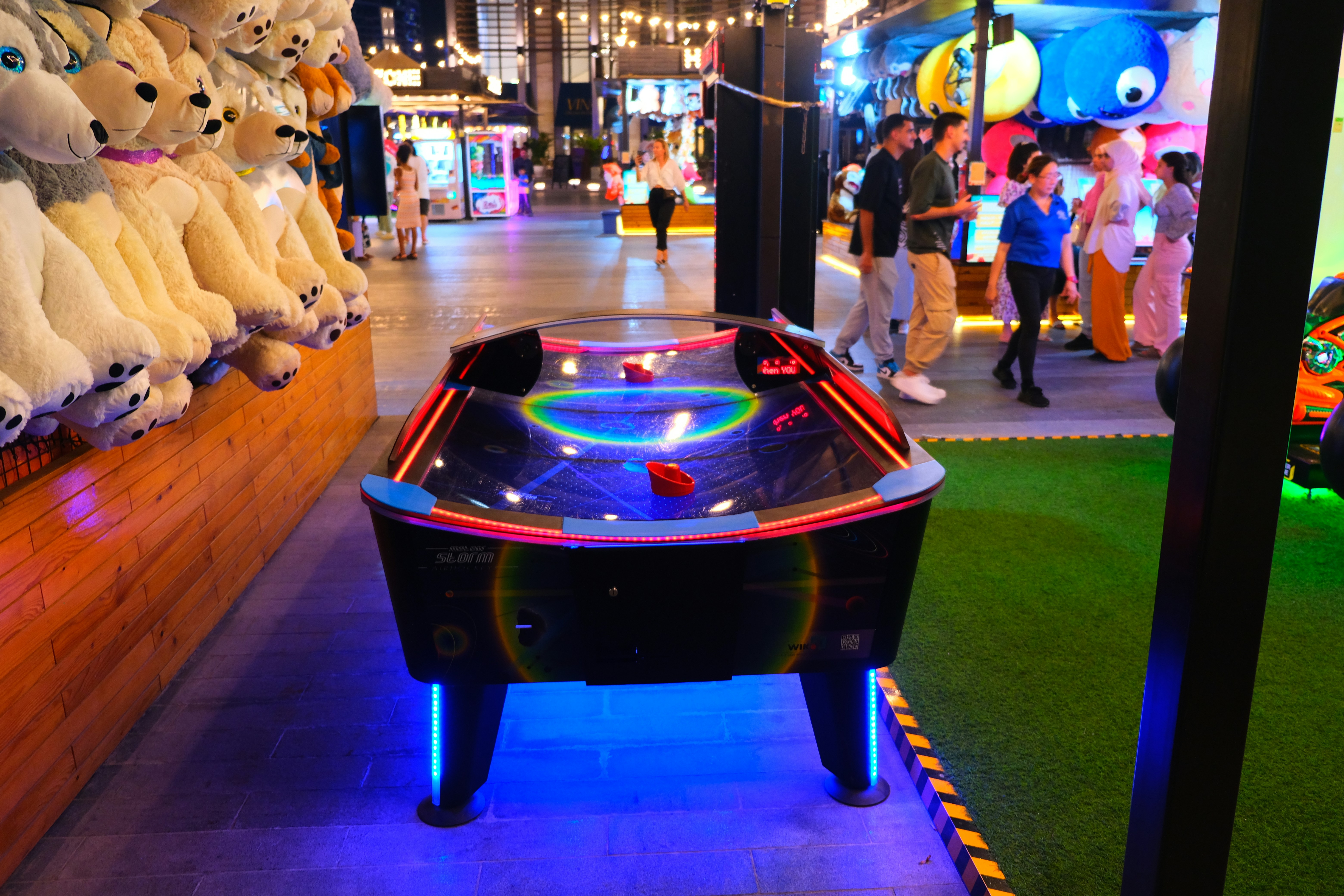 Neon-lit Air Hockey at a Busy Arcade