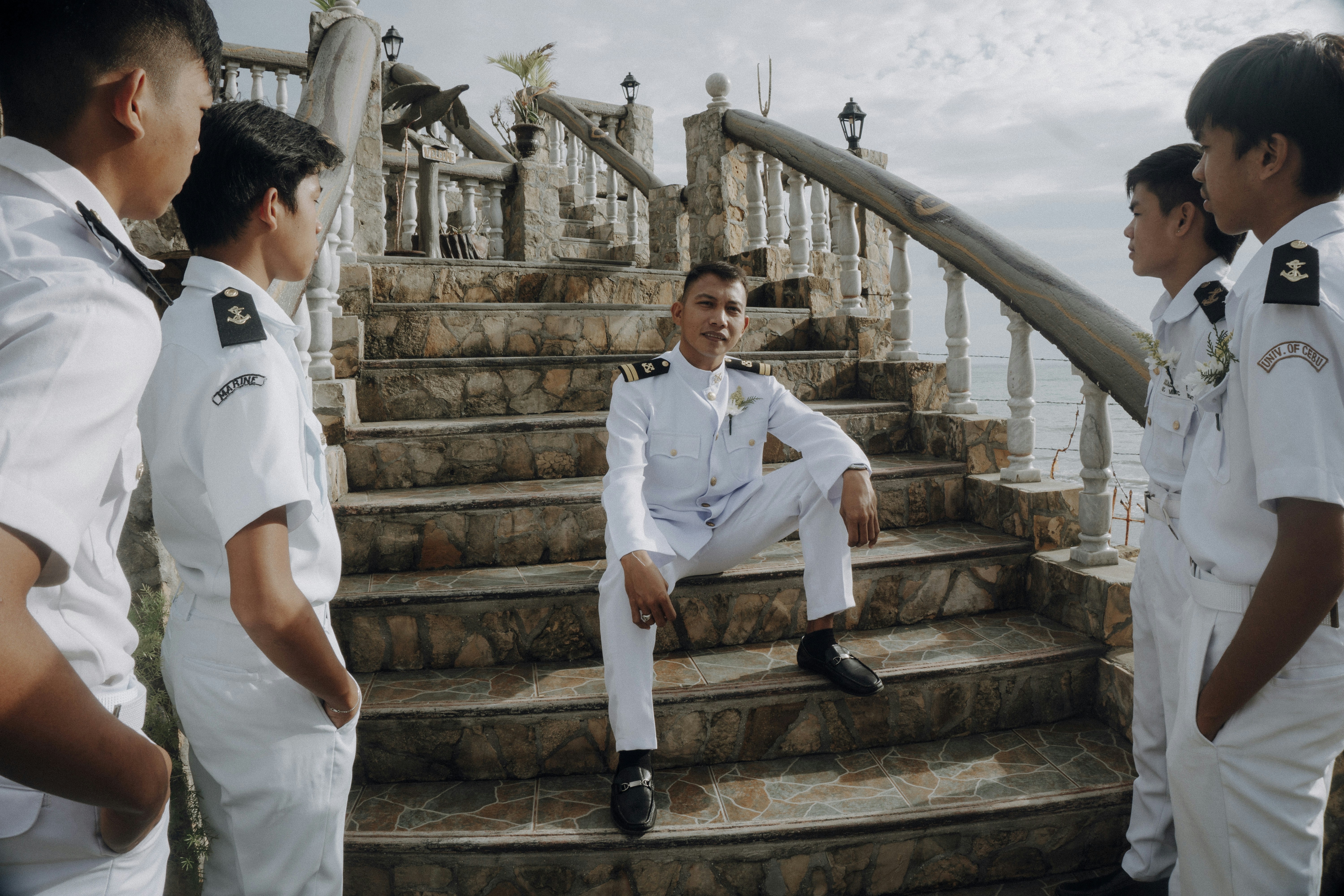 A man in a white suit sitting on a set of stairs photo – Free Man Image ...