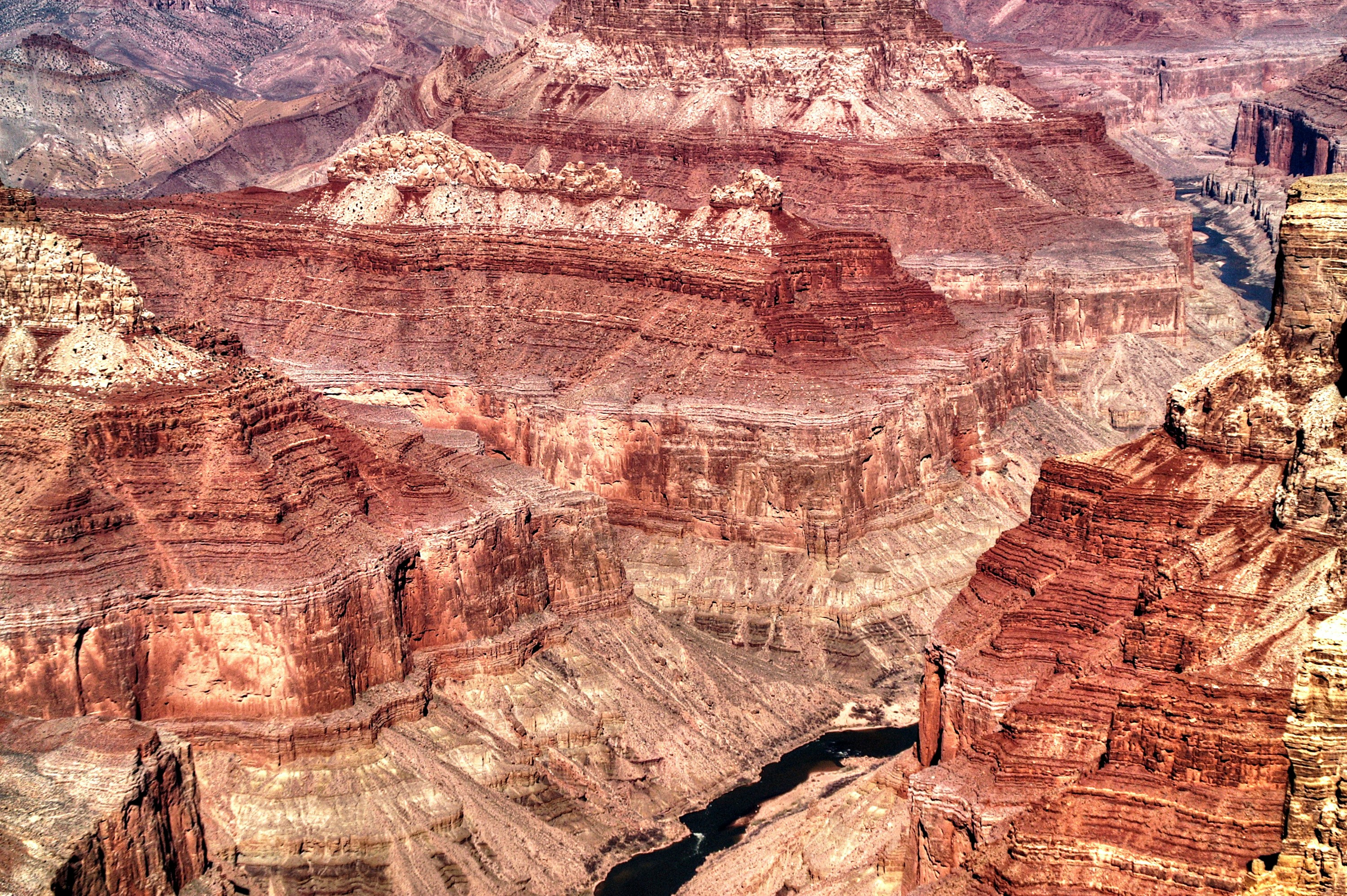 Vast expanse of the Grand Canyon showcasing intricate layers of rock formations and the winding Colorado River below.