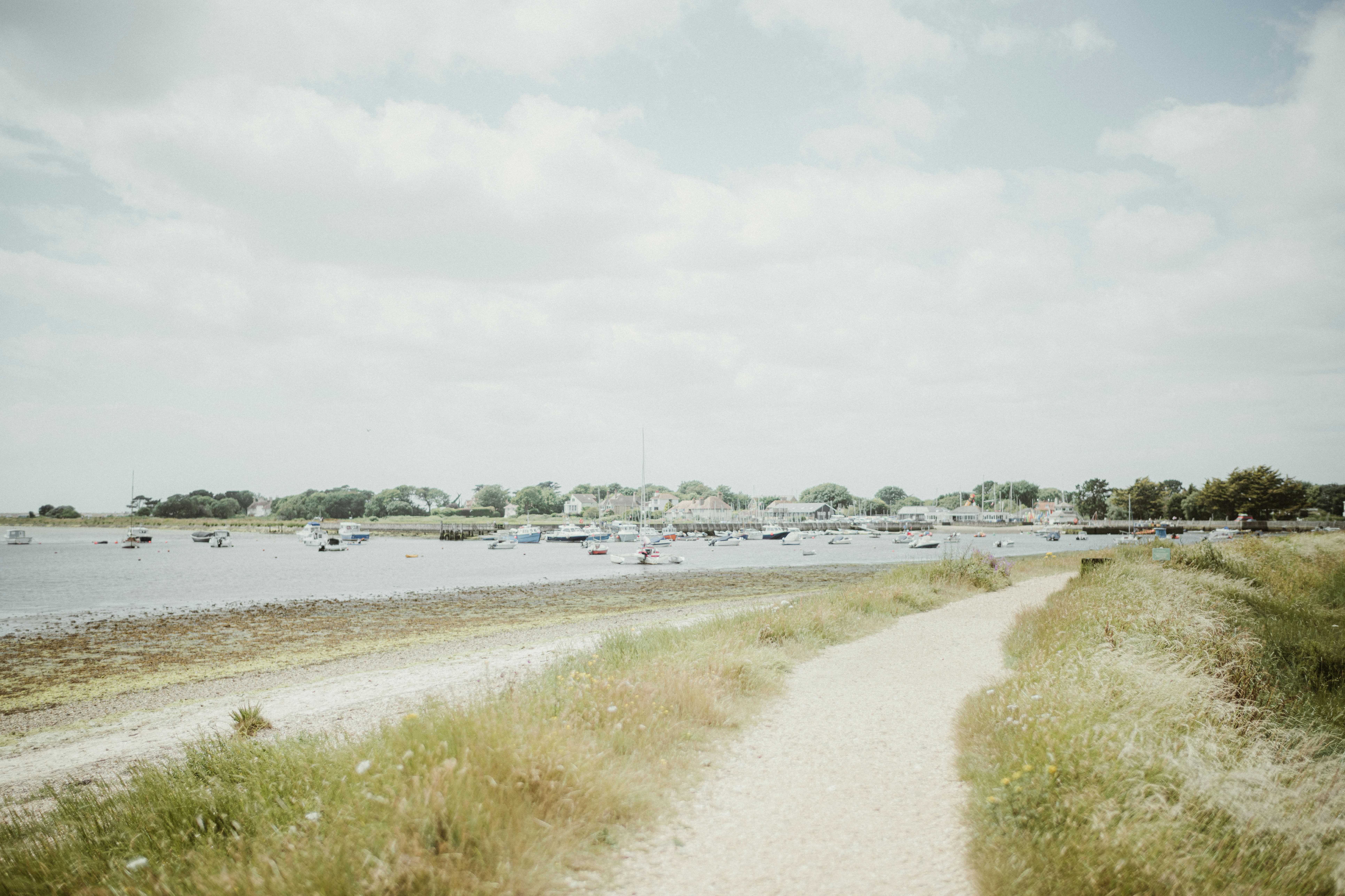 A path leading to a beach with boats in the water photo – Free Coast ...