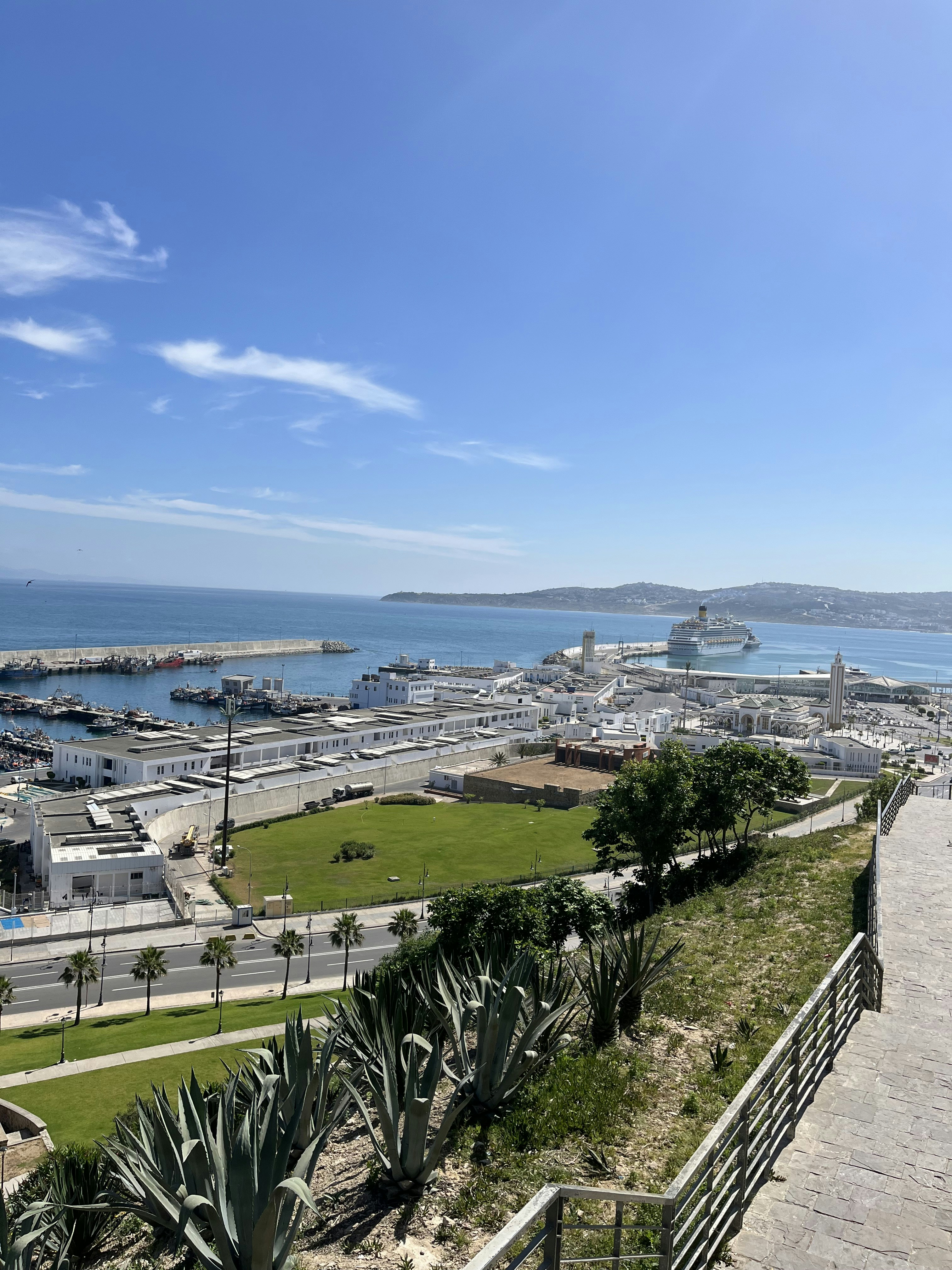 Harbor Vista: Sunlit Promenade toward a Grand Vessel