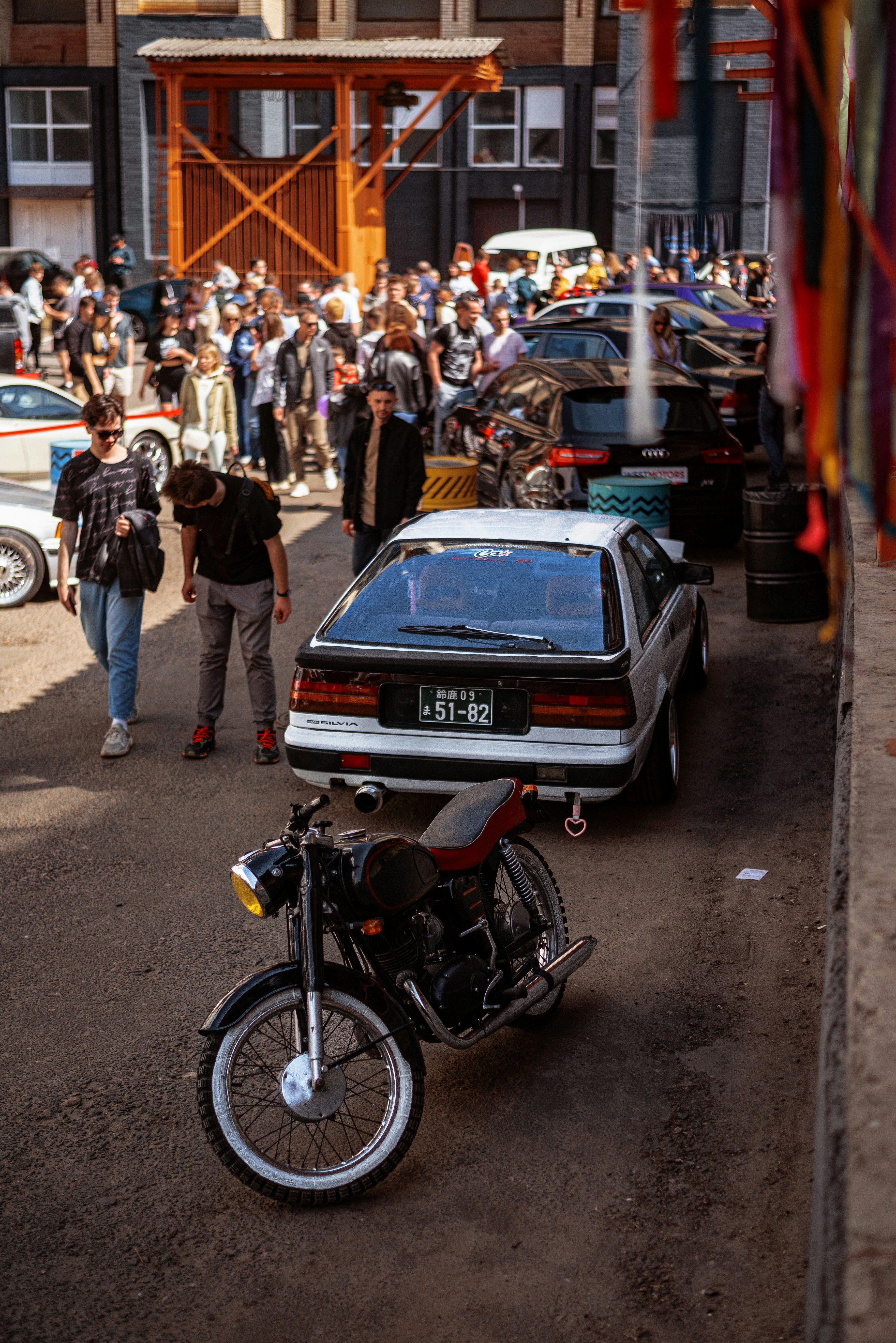 Street Spotlight: A Retro Motorcycle Framed by a Crowded Urban Scene