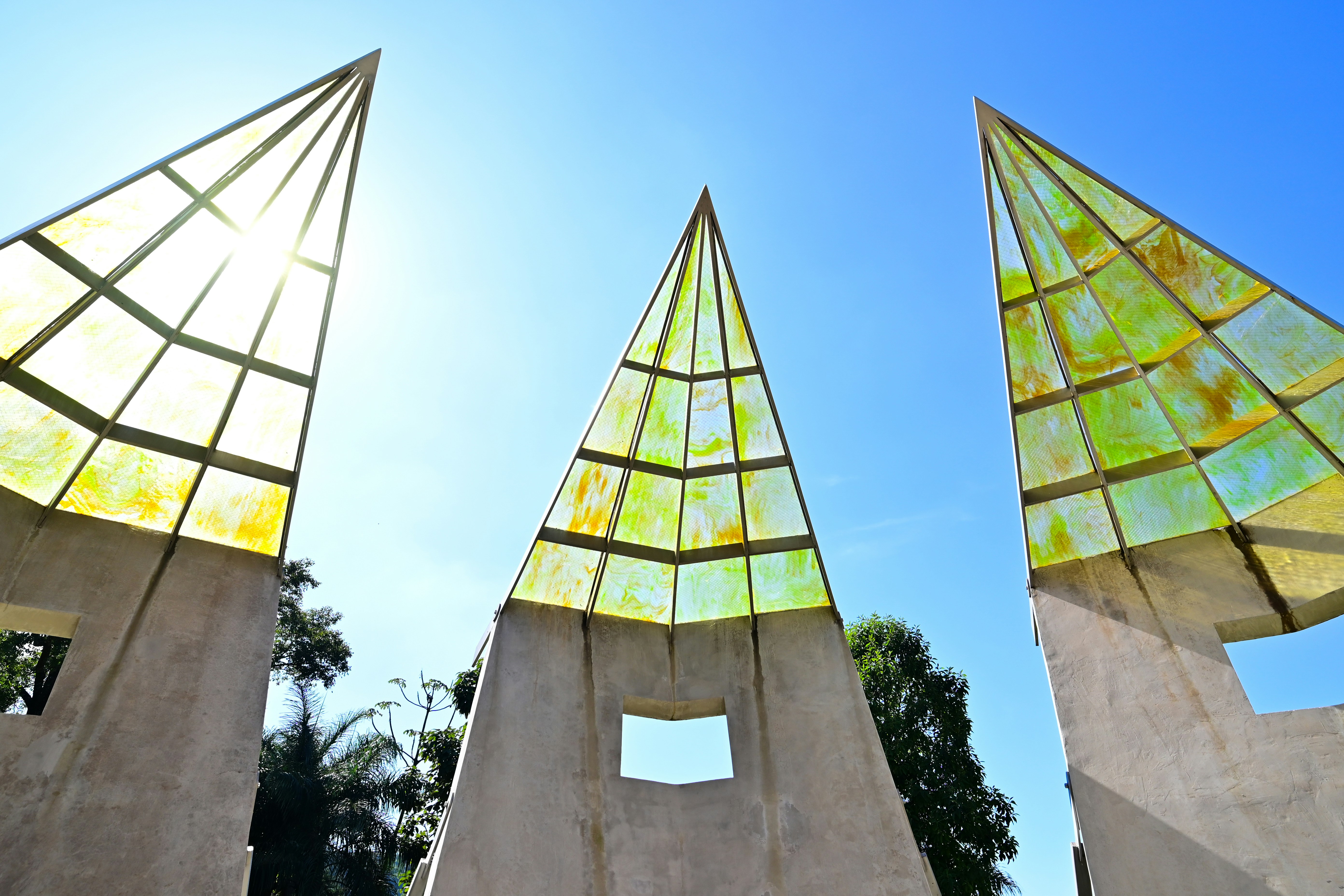 Prism Peaks: Sunlit Triangular Glass Towers Against a Clear Sky