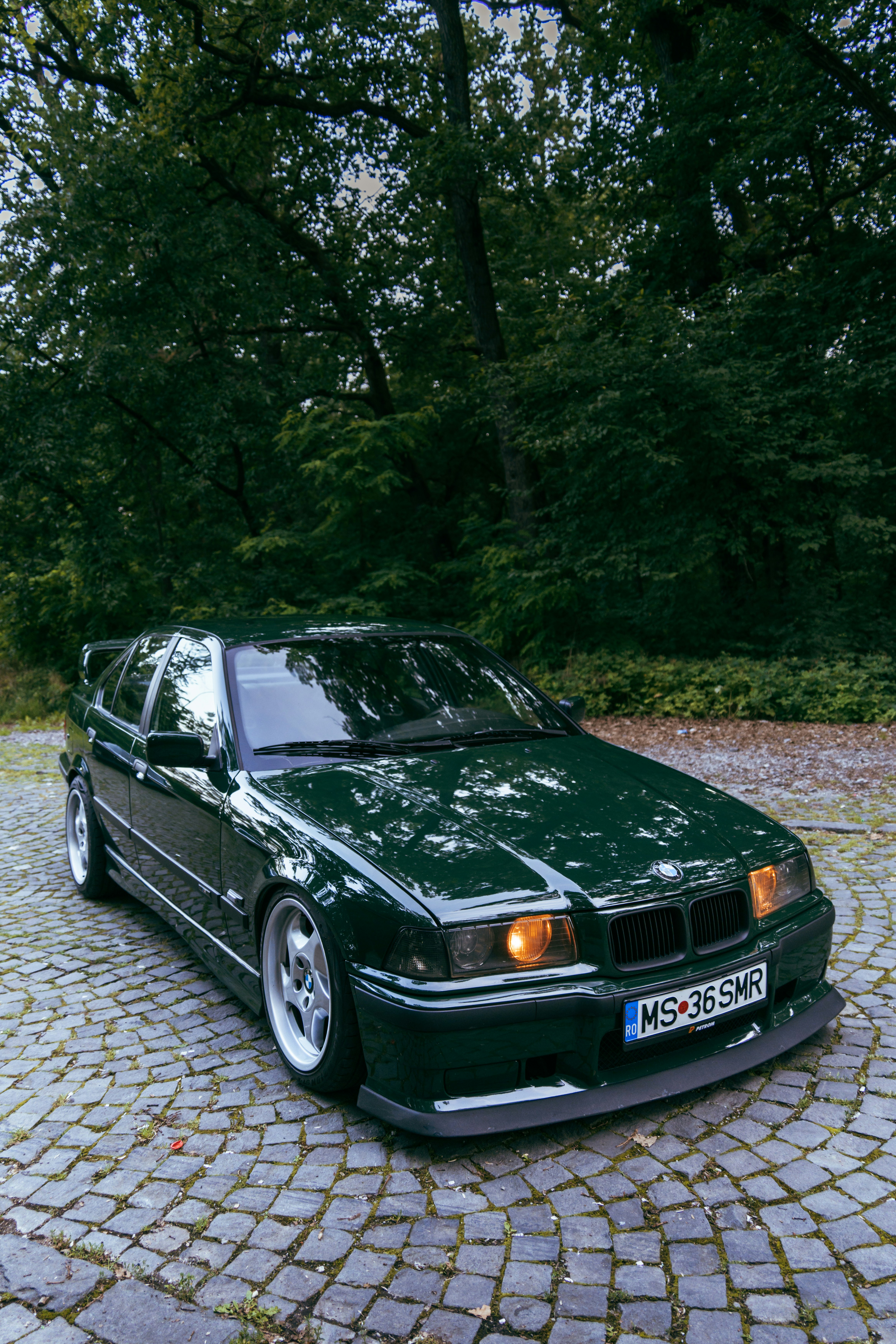 Ein grünes Auto, das auf einer Kopfsteinpflasterstraße geparkt ist Foto ...