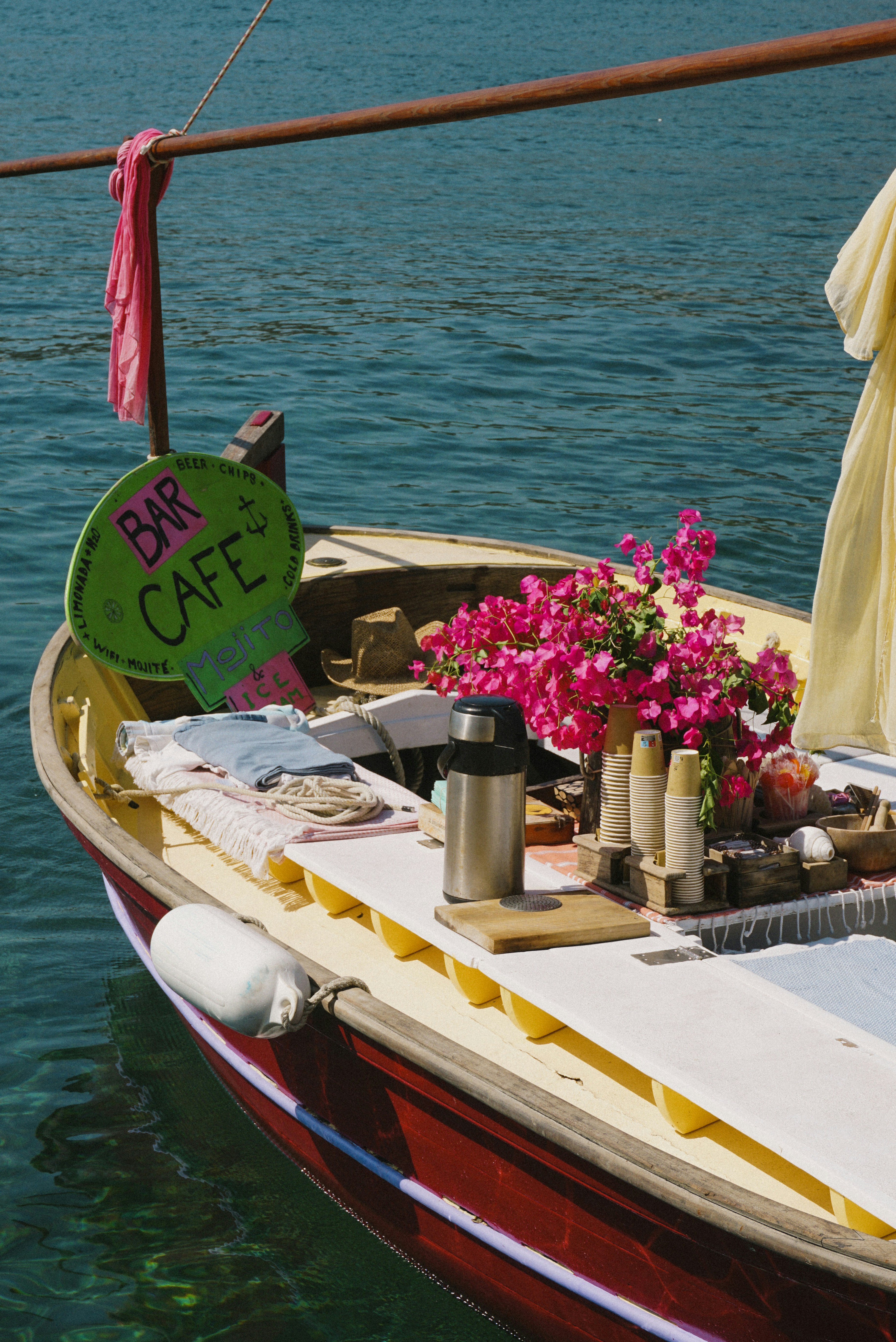 Floating Bar Café Sign Anchors a Burst of Color on a Sunlit Boat