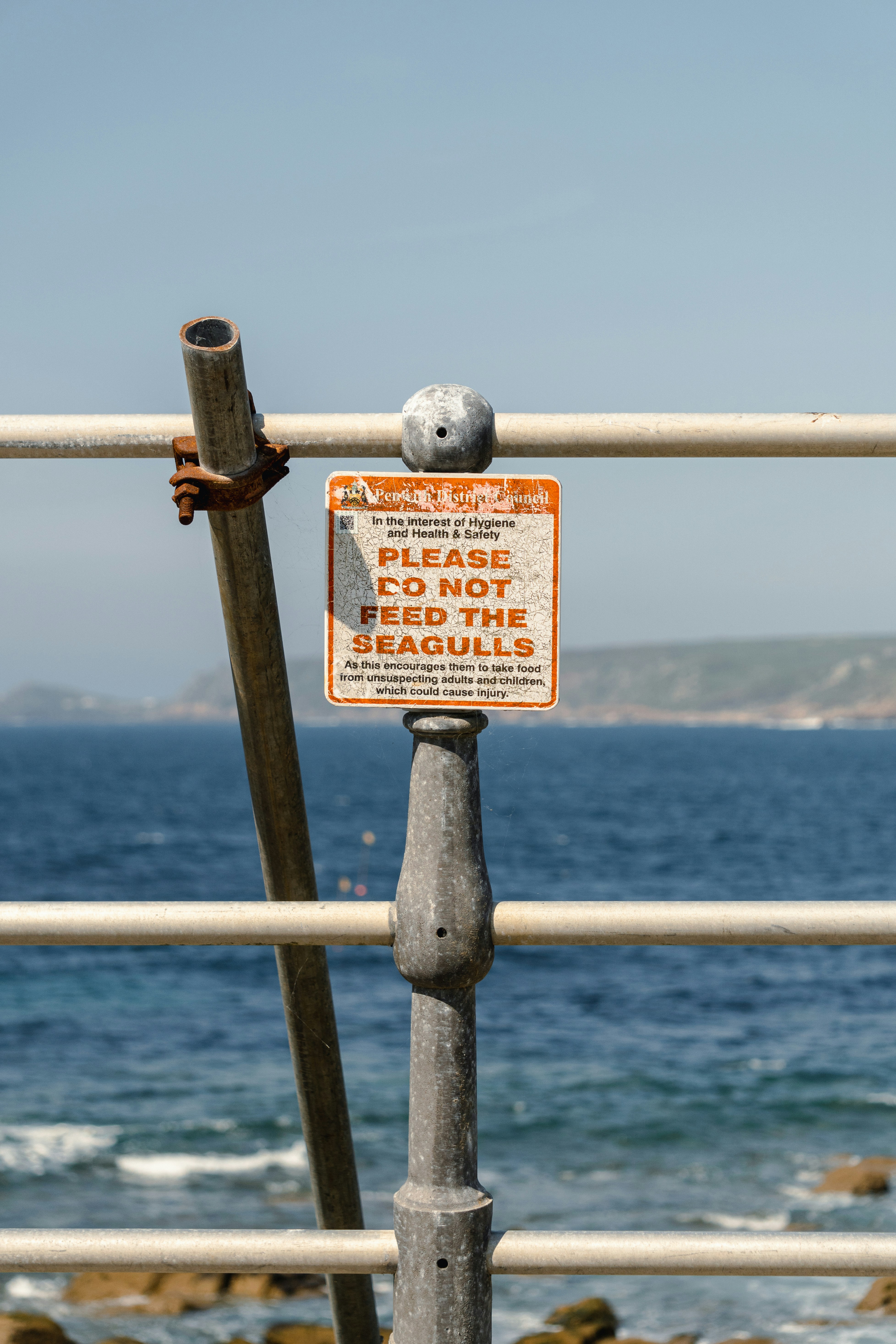 Rusted Signpost Framing a Quiet Coastal Scene