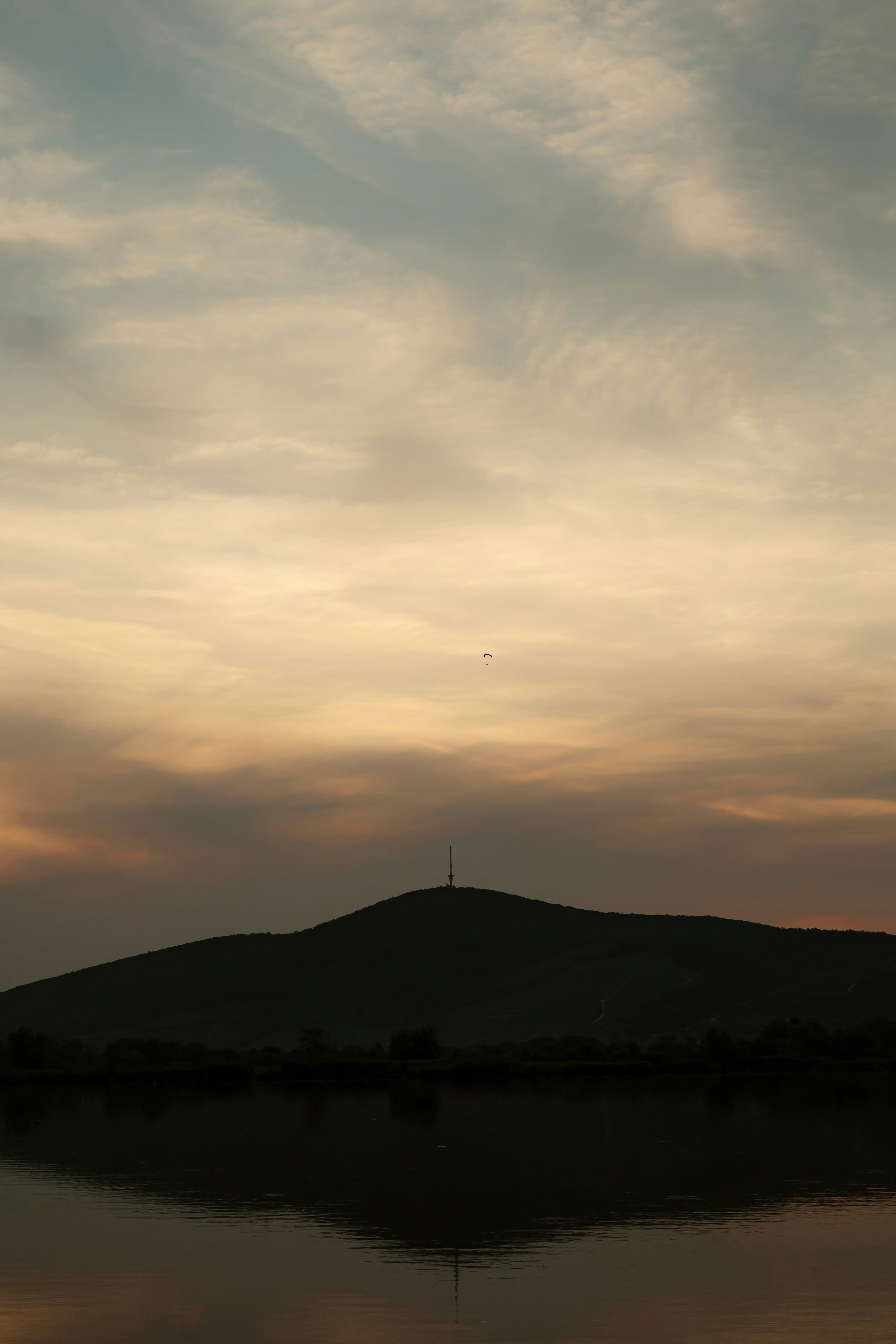 Evening Silhouette Over a Quiet Lake: Towered Hill at Sunset