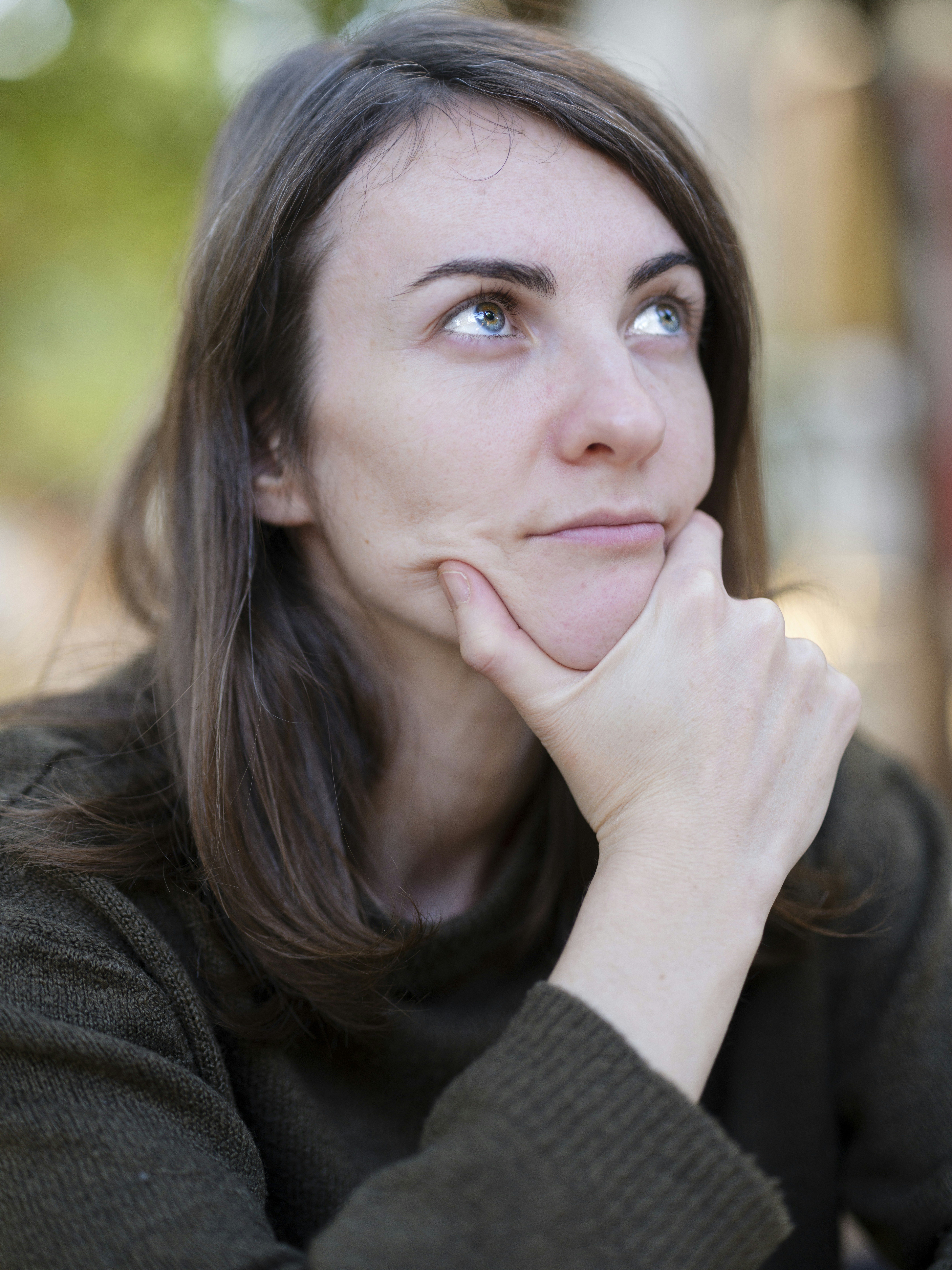 A woman with her chin resting on her hand photo – Free Face Image on ...