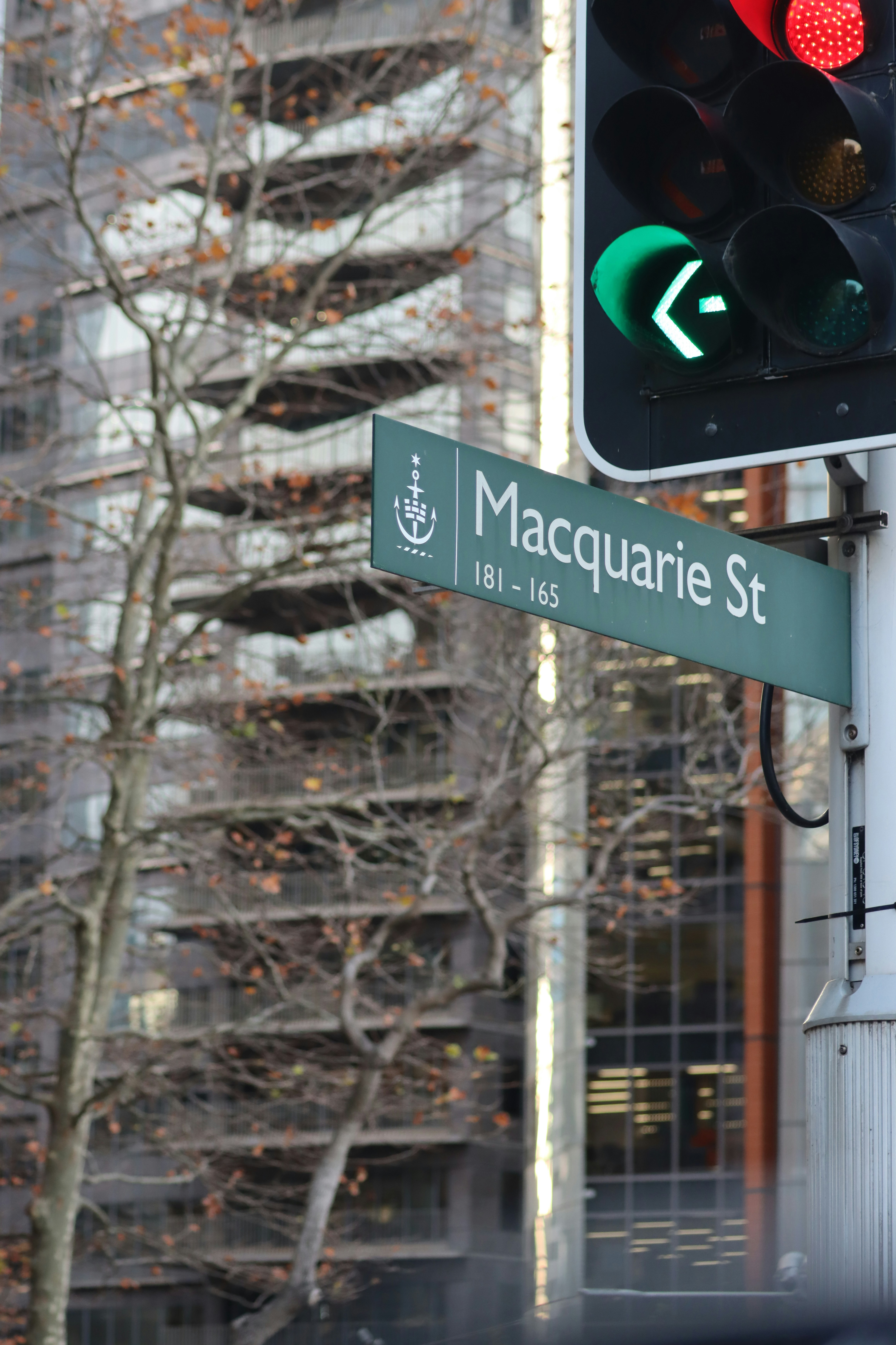 A traffic light and street sign in front of a tall building photo ...