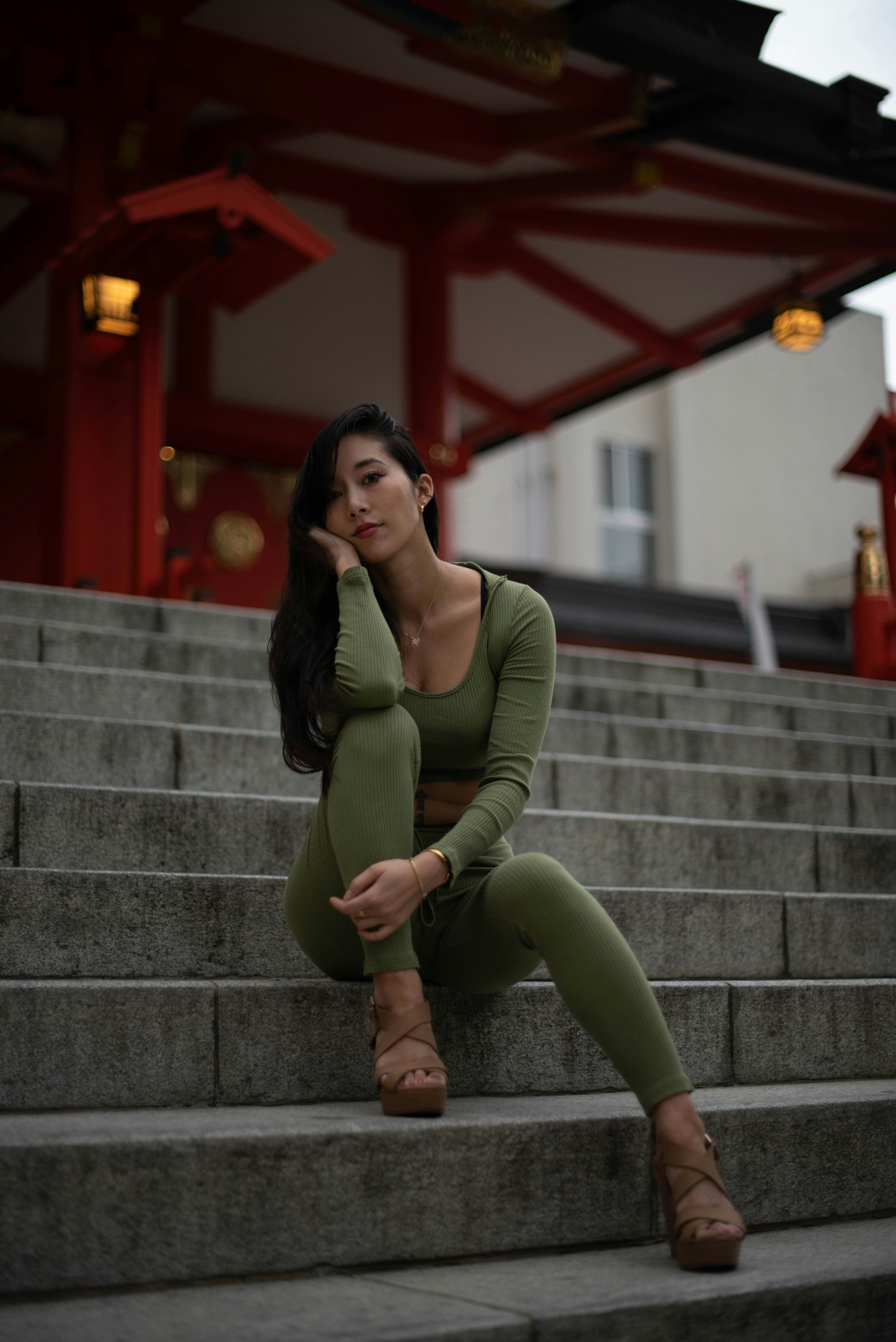 A woman sitting on some steps in front of a building photo – Free ...