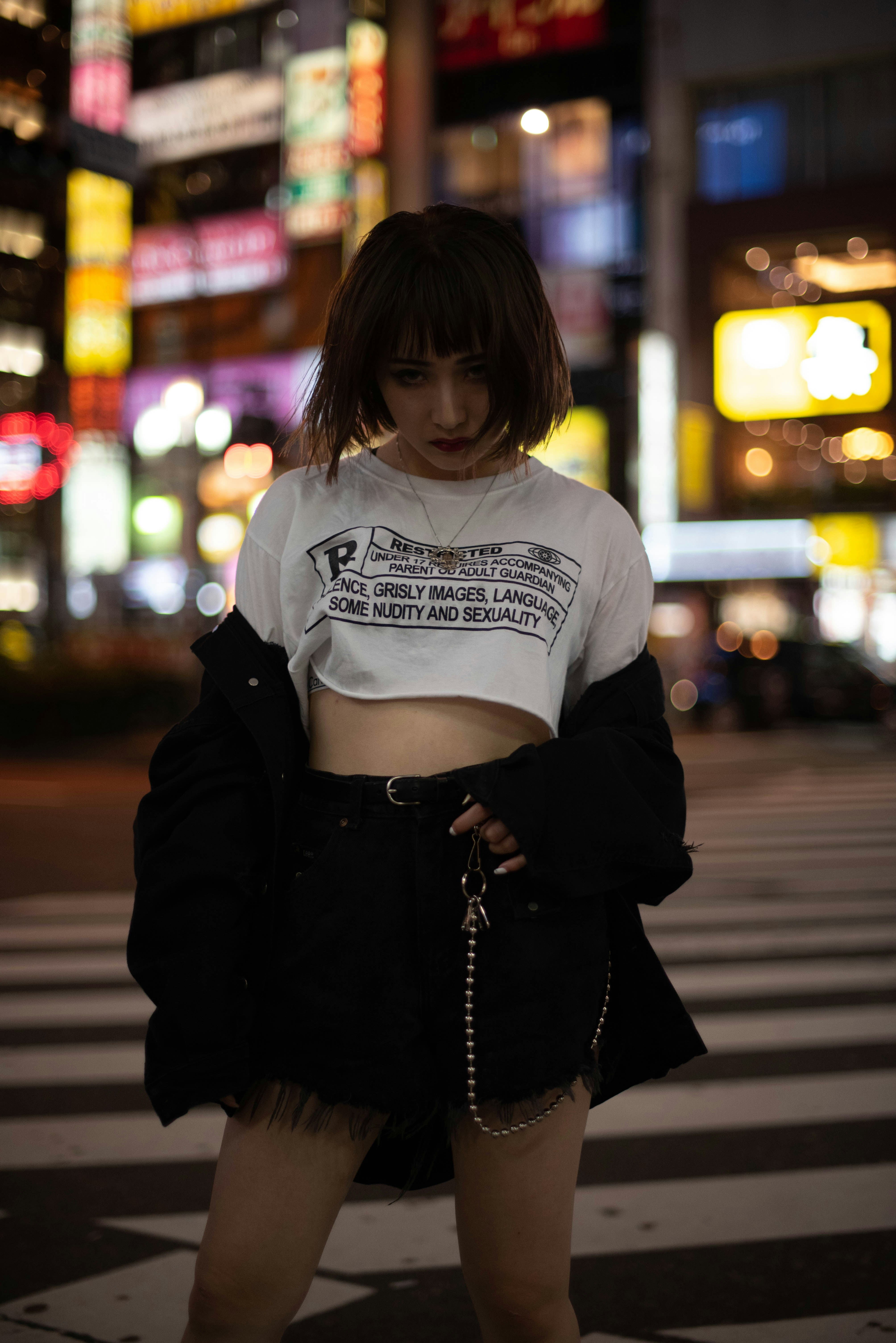 Neon Crosswalk Portrait: Cropped White Tee Amid City Lights